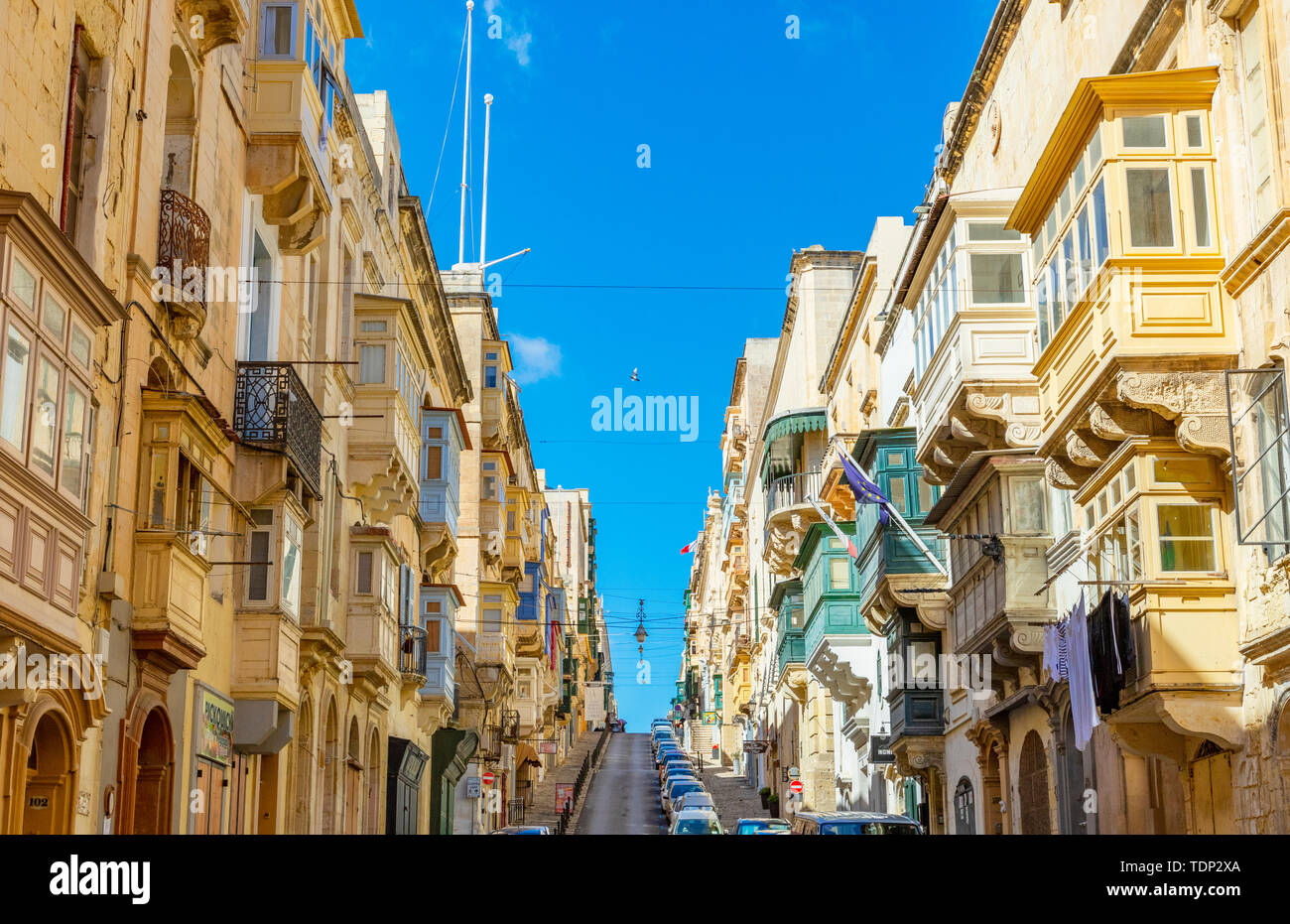 Typical narrow maltese streets with colorful traditional windows and ...