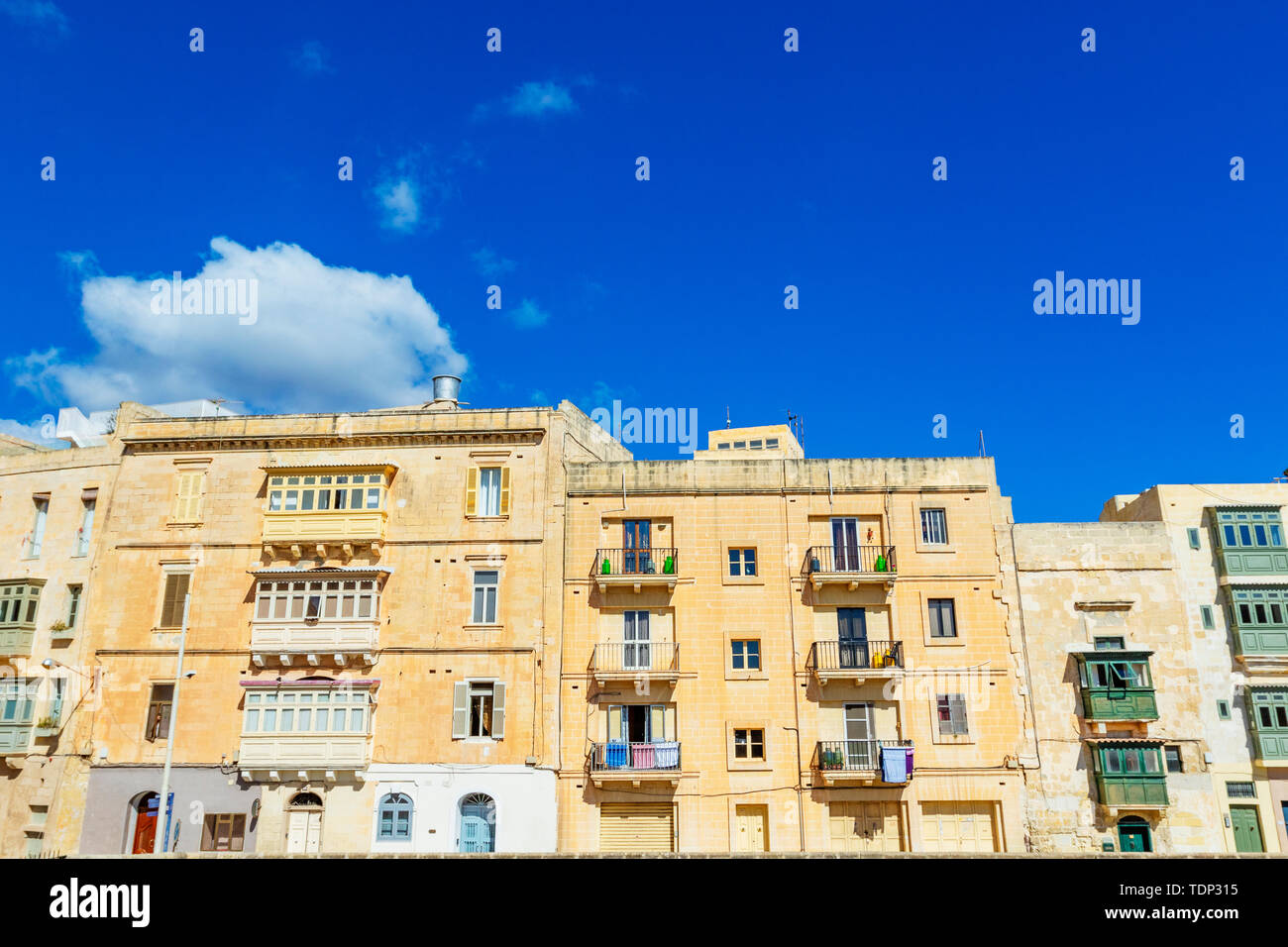 Typical narrow maltese streets with colorful traditional windows and ...