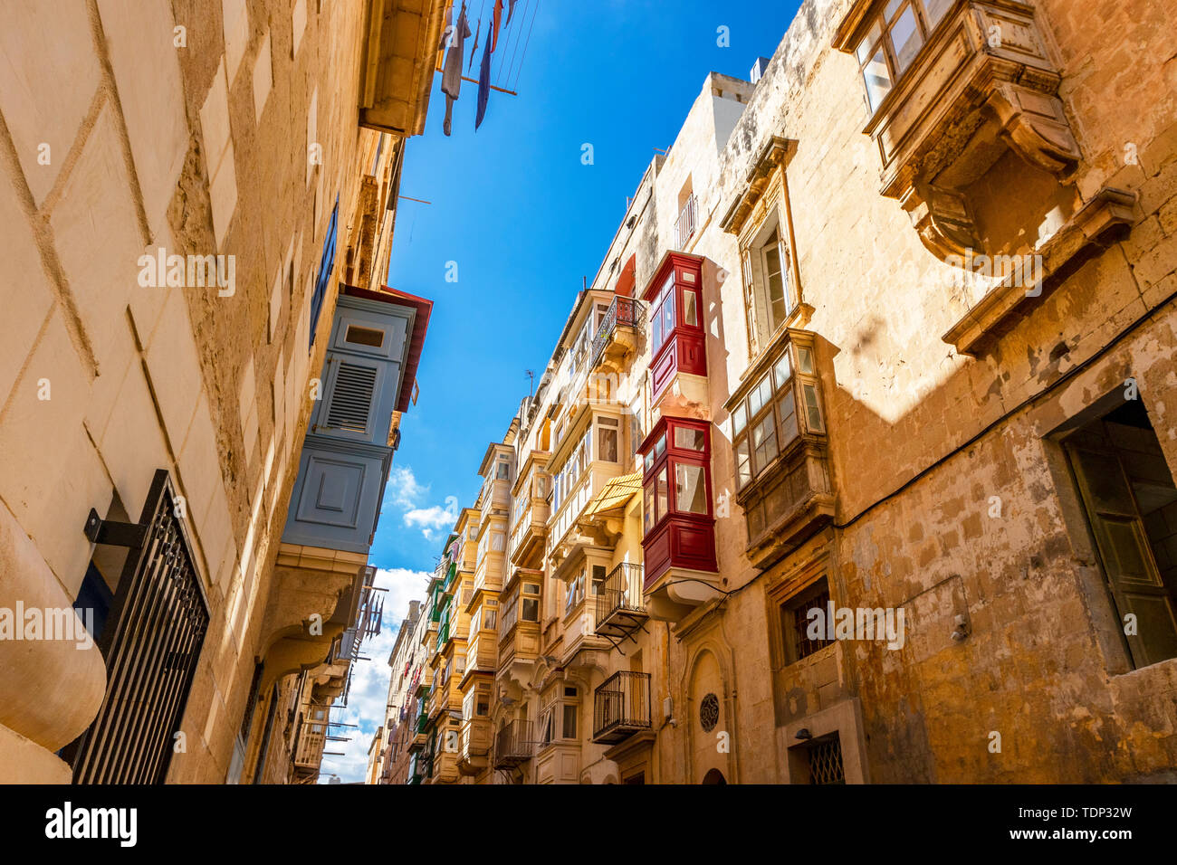 Typical narrow maltese streets with colorful traditional windows and ...