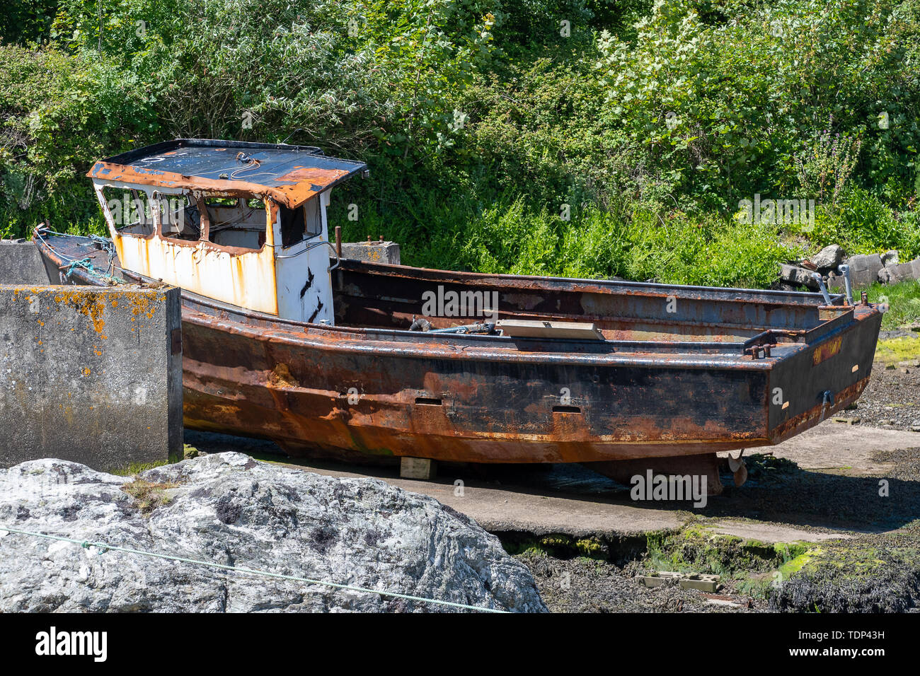 Old rusting derelict boat left on a beach Stock Photo - Alamy