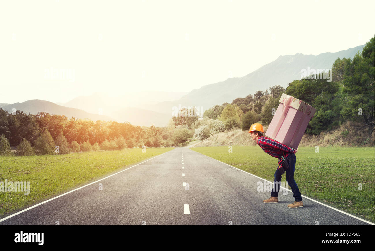 Man carrying on his back large box Stock Photo - Alamy