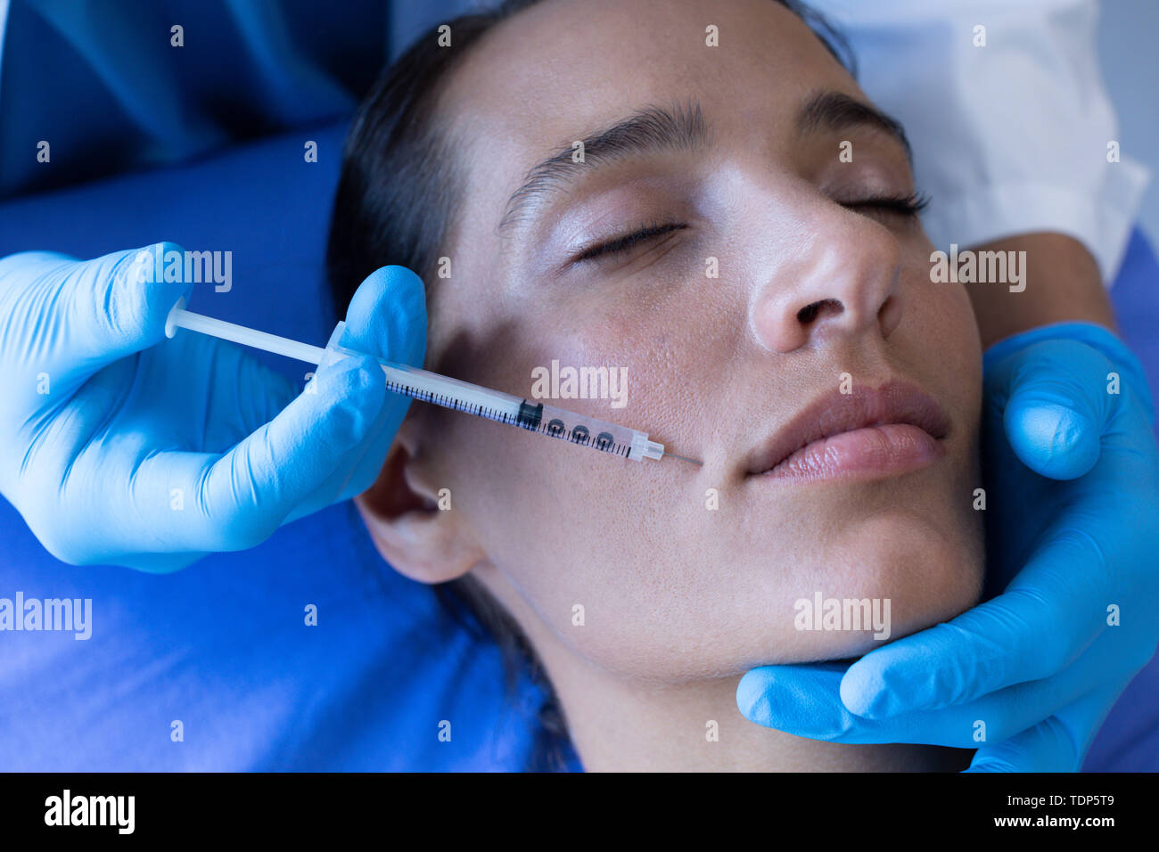 Surgeon giving injection to face of female patient Stock Photo - Alamy