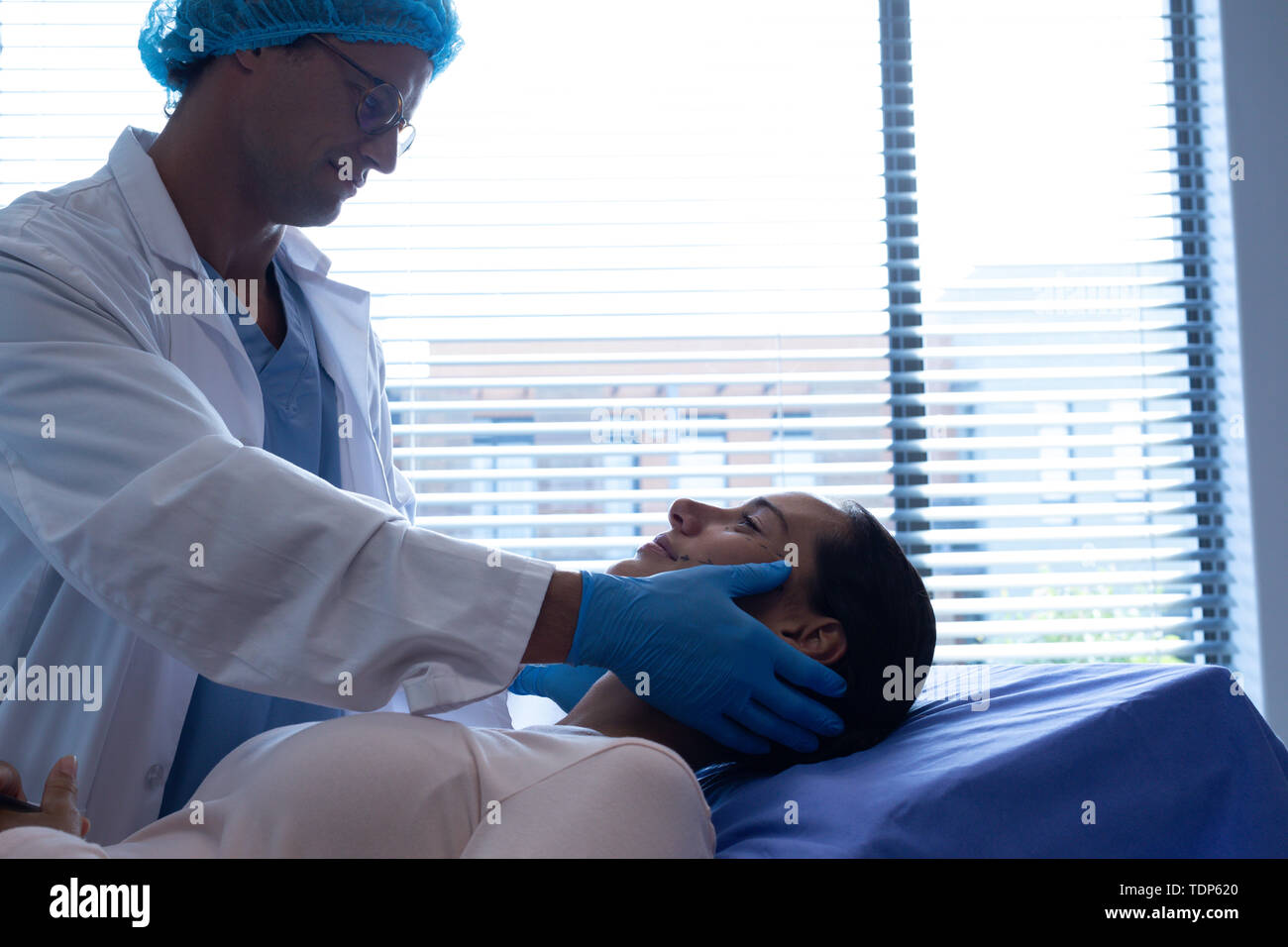 Male surgeon examining female patient in hospital Stock Photo - Alamy
