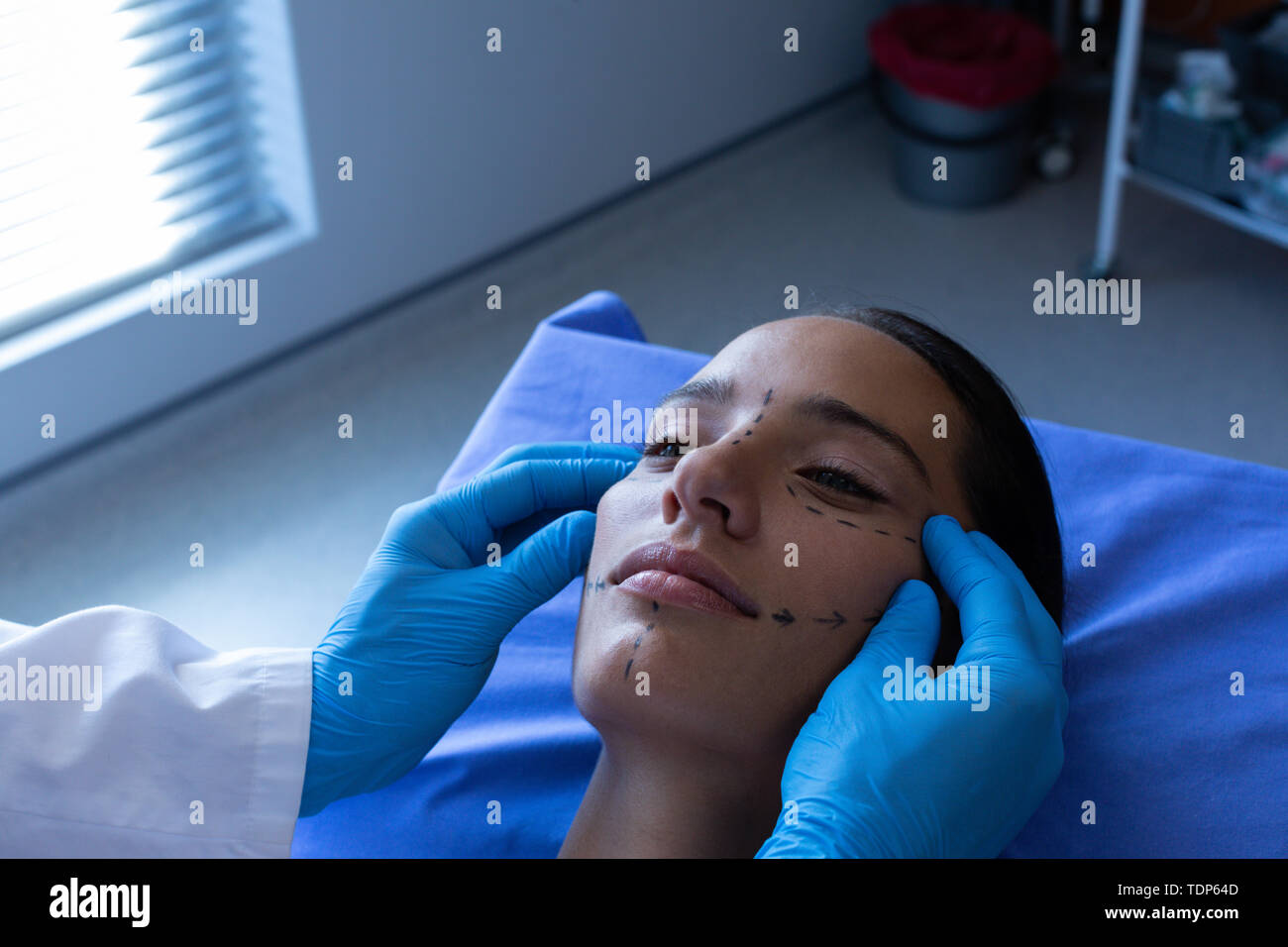 Male surgeon examining female patient face Stock Photo - Alamy