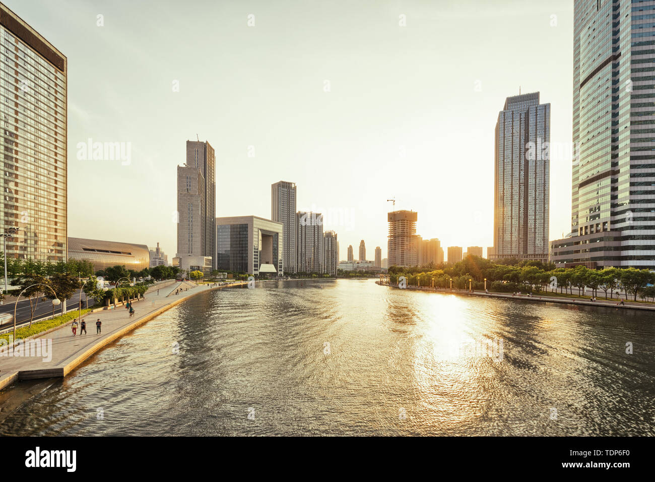 Modern skyline at riverbank during sunset Stock Photo - Alamy