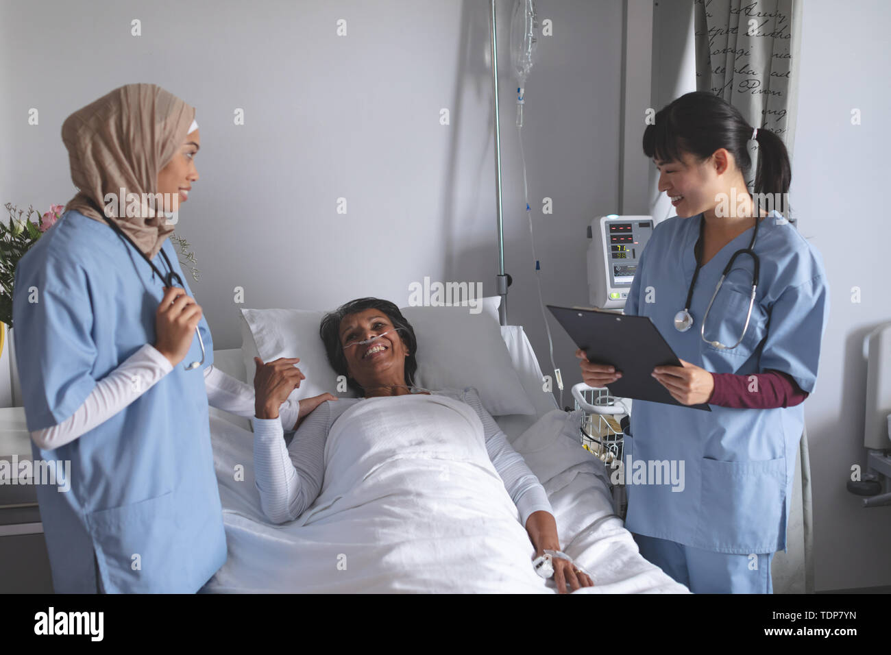 Female doctors interacting with female patient in the ward Stock Photo ...