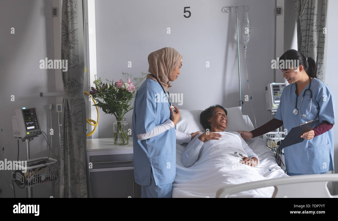Female doctors interacting with female patient in the ward Stock Photo ...