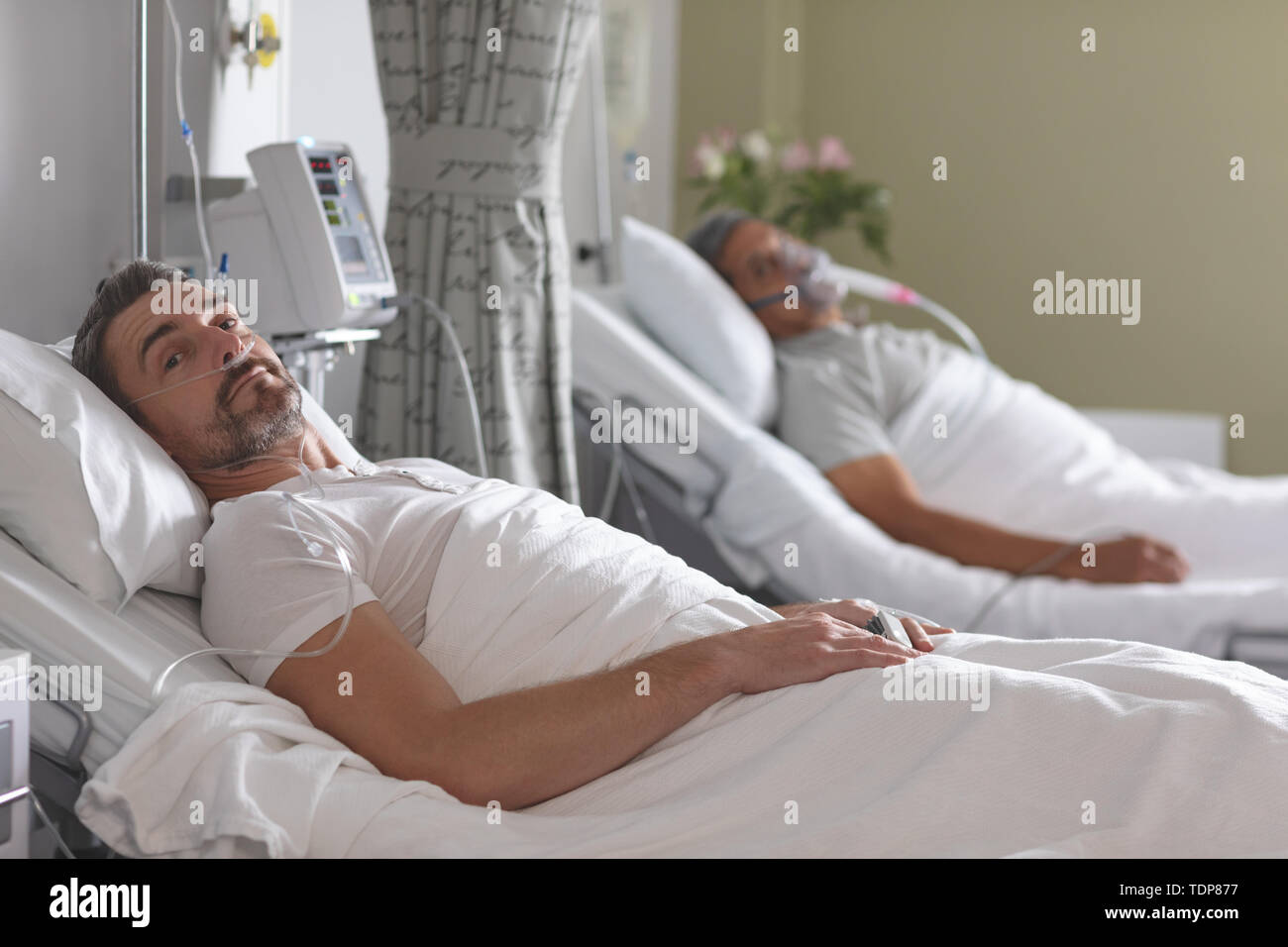 Male patient relaxing in bed in the ward at hospital Stock Photo - Alamy