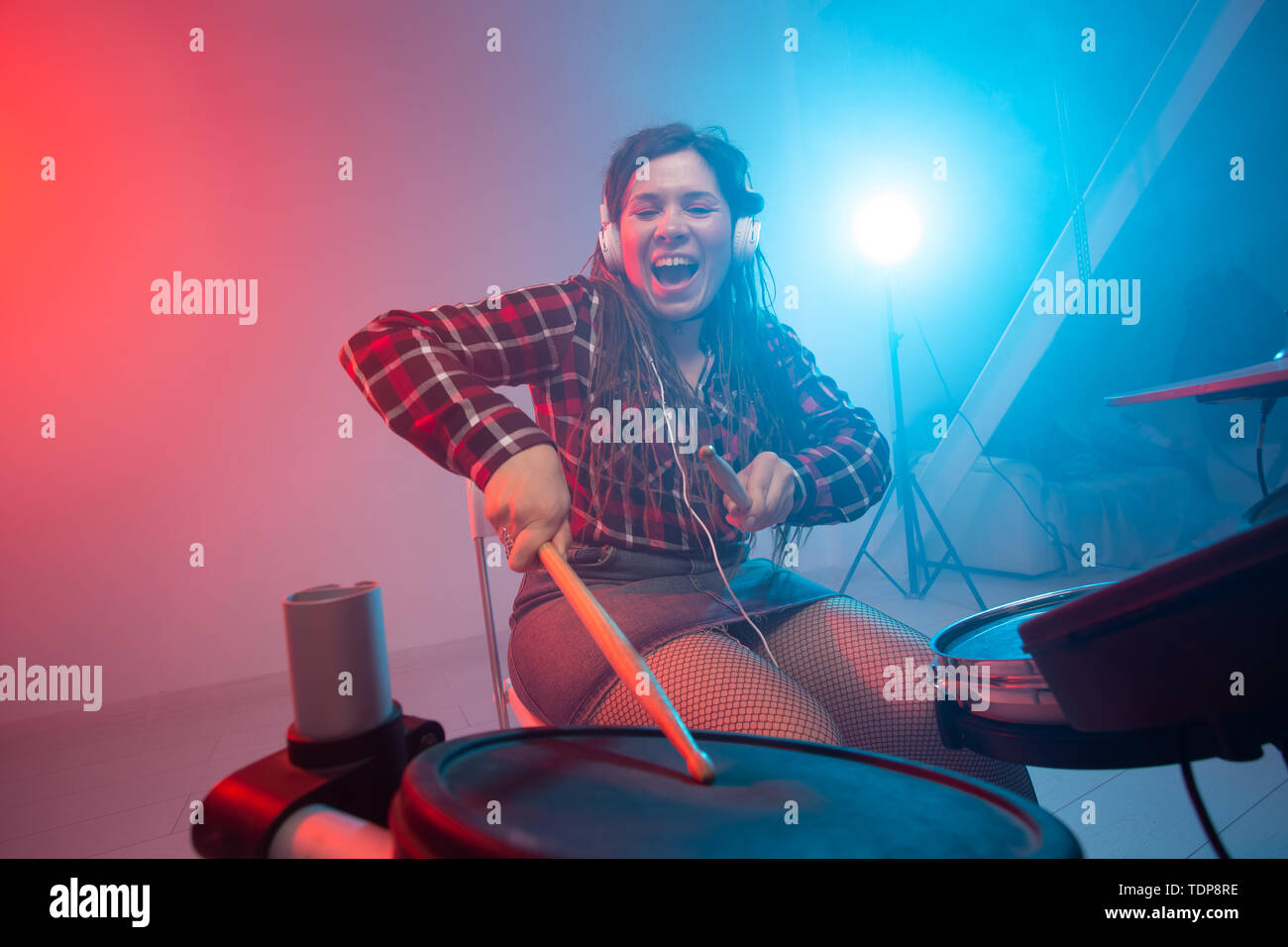 Electronic drum set, music and hobby concept - young woman drummer ...