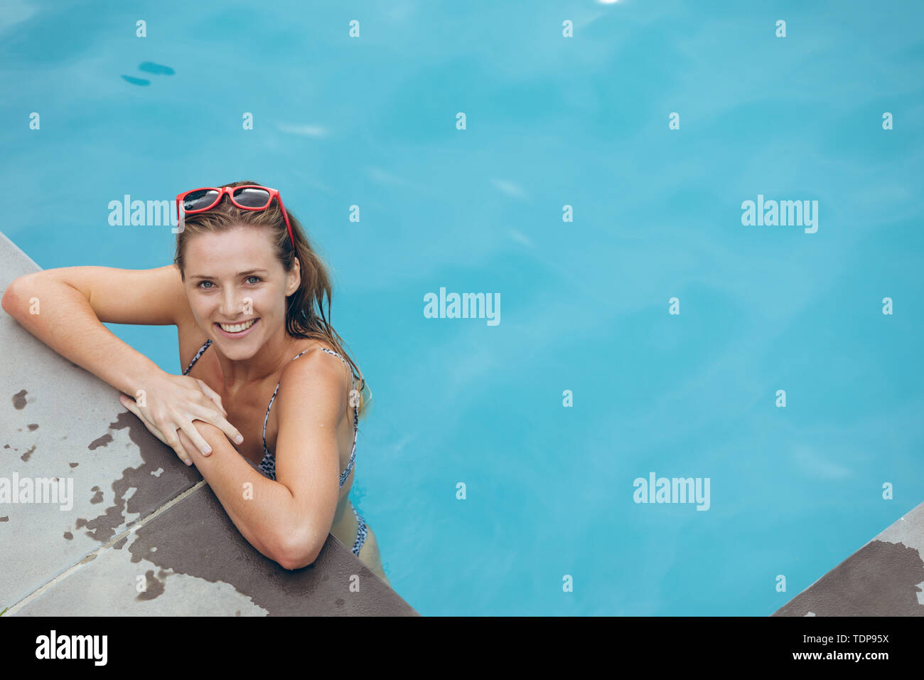 Happy woman standing at the edge of swimming pool Stock Photo - Alamy