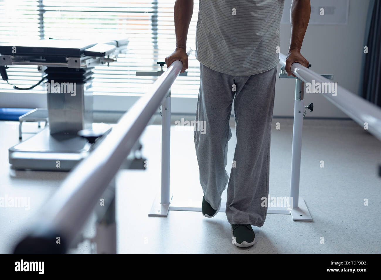 Male patient walking with parallel bars in hospital Stock Photo - Alamy