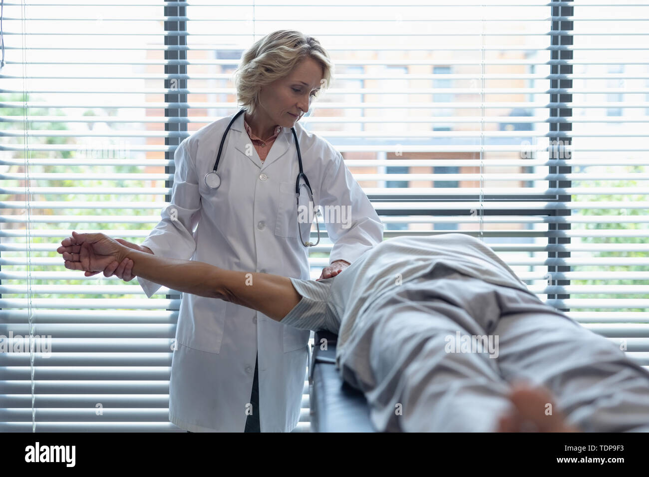 Female doctor examining patient arm in hospital Stock Photo - Alamy