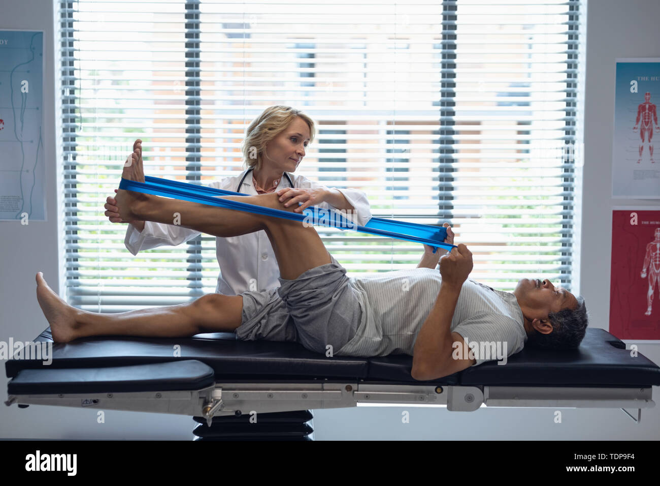 Female doctor examining patient leg with resistance band Stock Photo ...