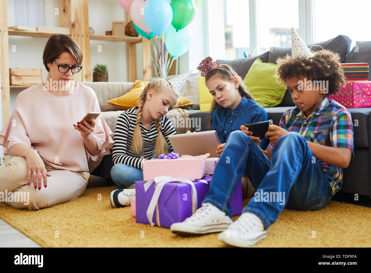 Full length view at group of kids using smartphones during Birthday ...
