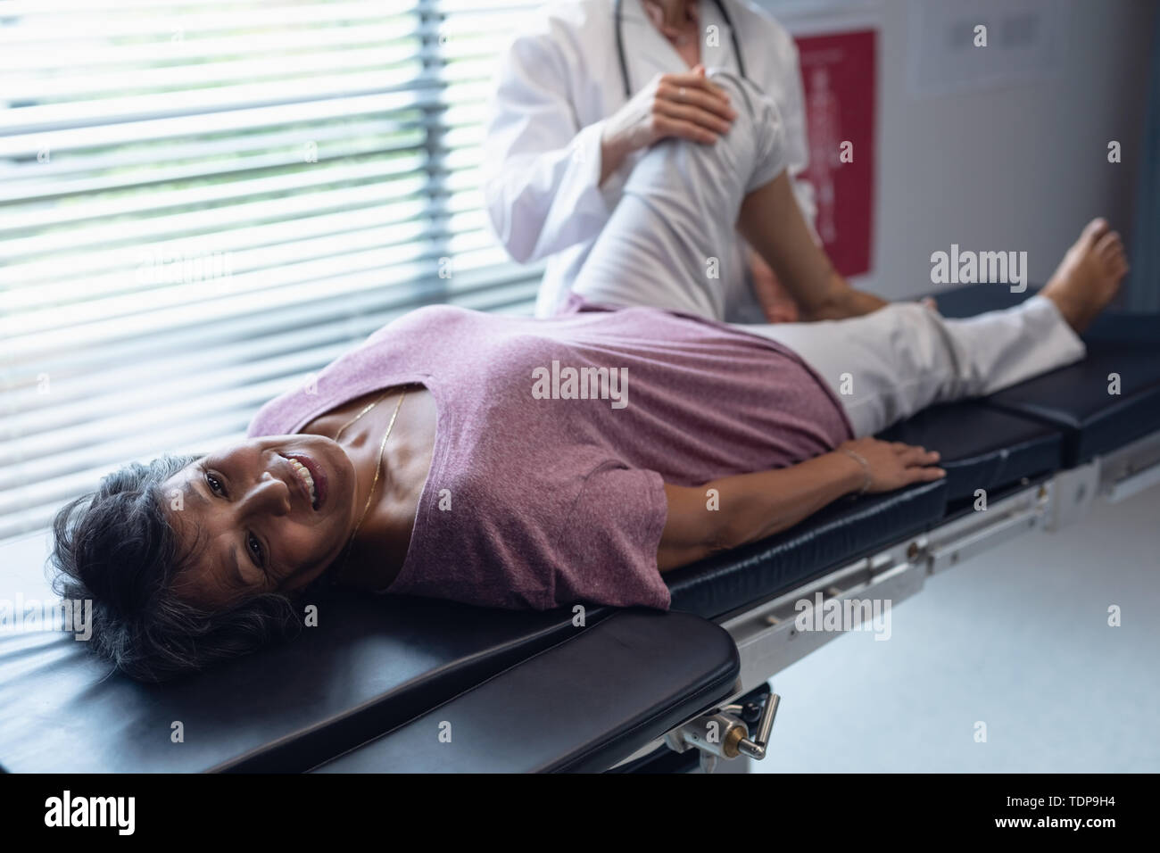 Female doctor examining her patient leg Stock Photo - Alamy