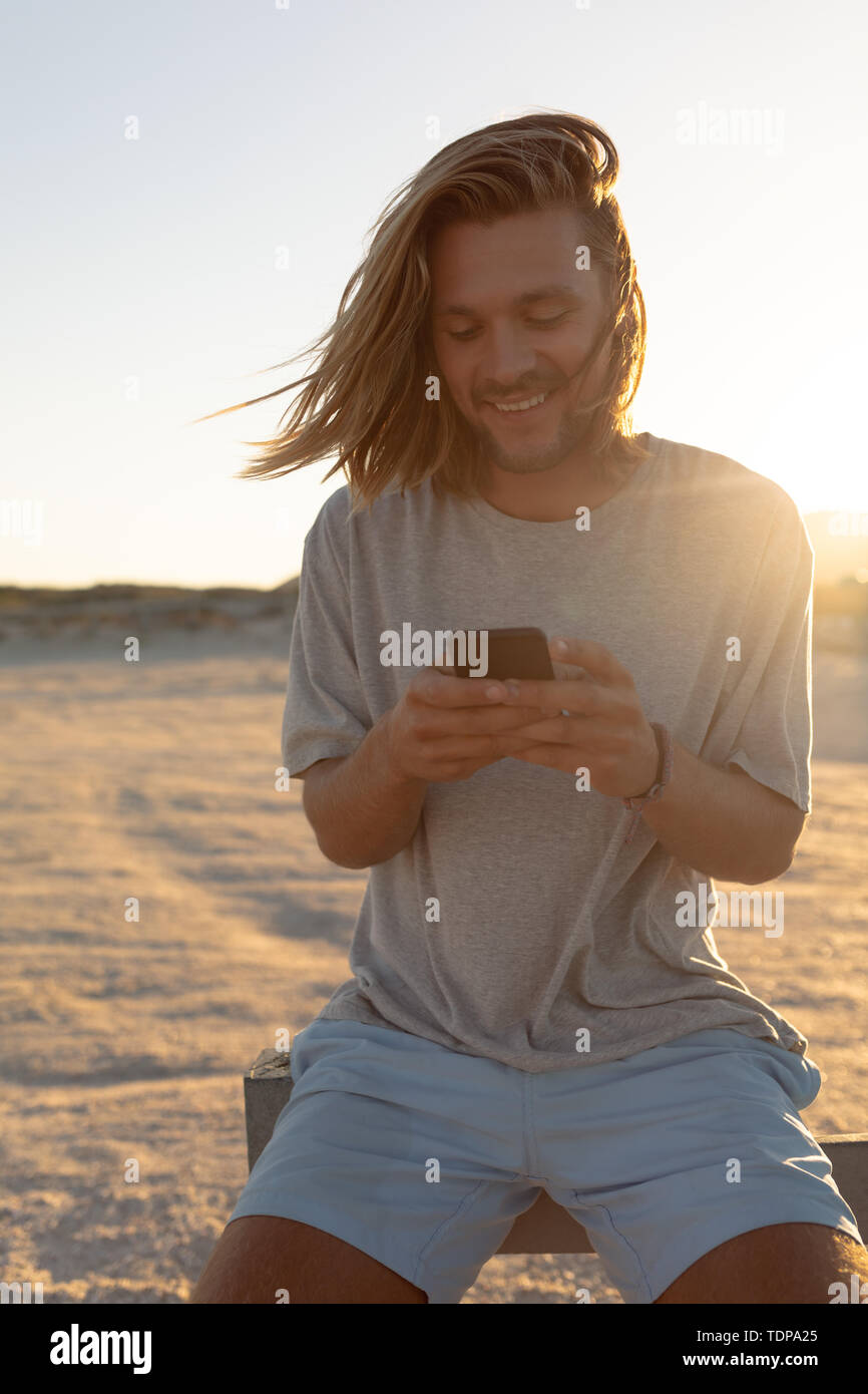 Young man using mobile phone at beach Stock Photo - Alamy