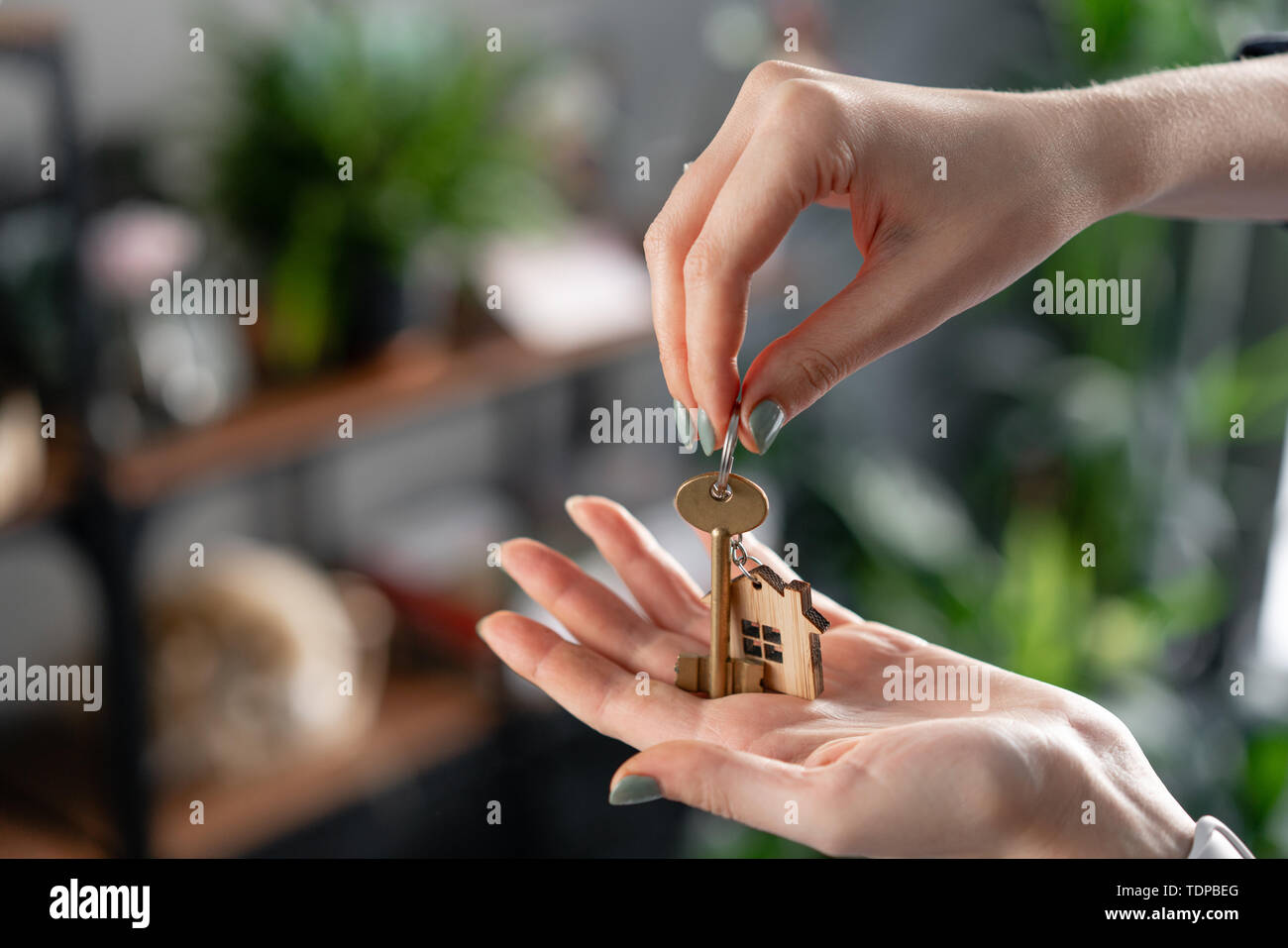 Mortgage concept. House key in womans hands. Young woman. Modern light ...