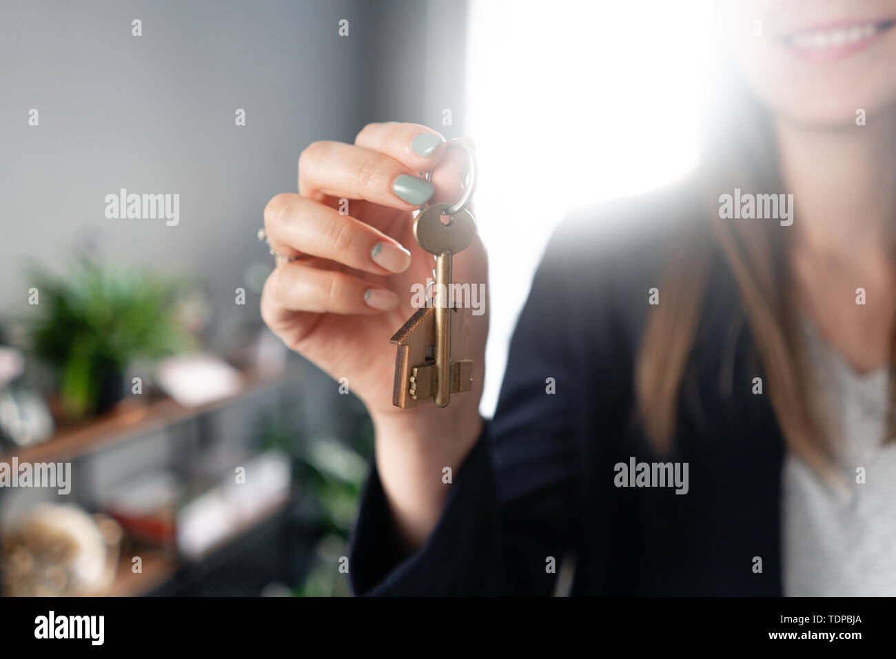 House key rotates on the finger in womans hands. Young pretty woman ...