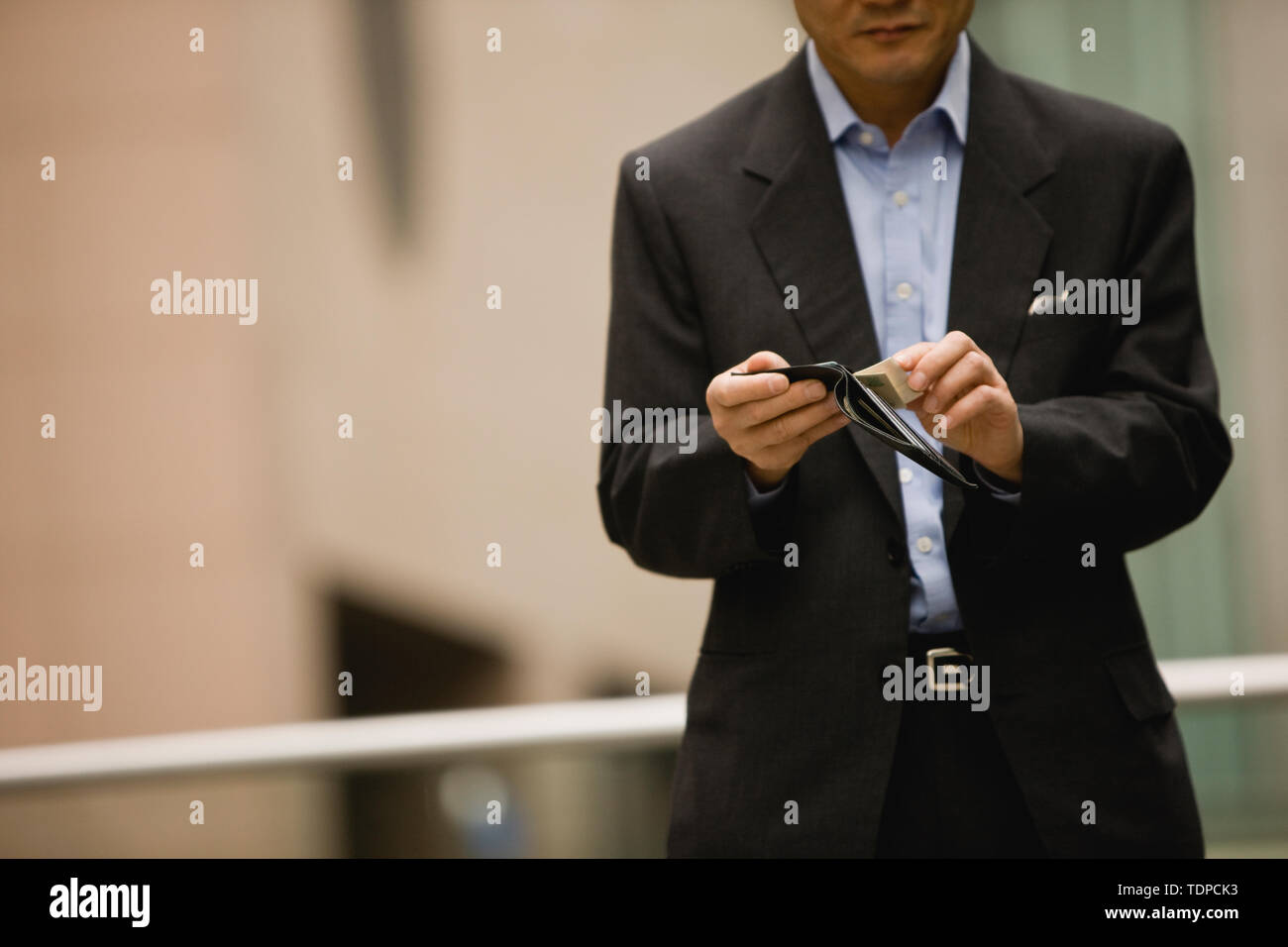 Suited businessman opening up his wallet Stock Photo - Alamy