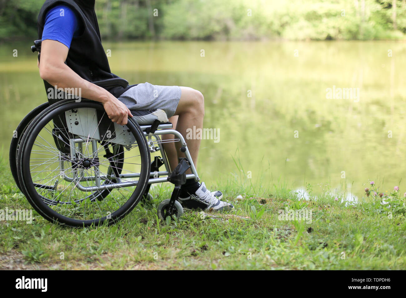 Happy and young disabled or handicapped man sitting on a wheelchair in ...