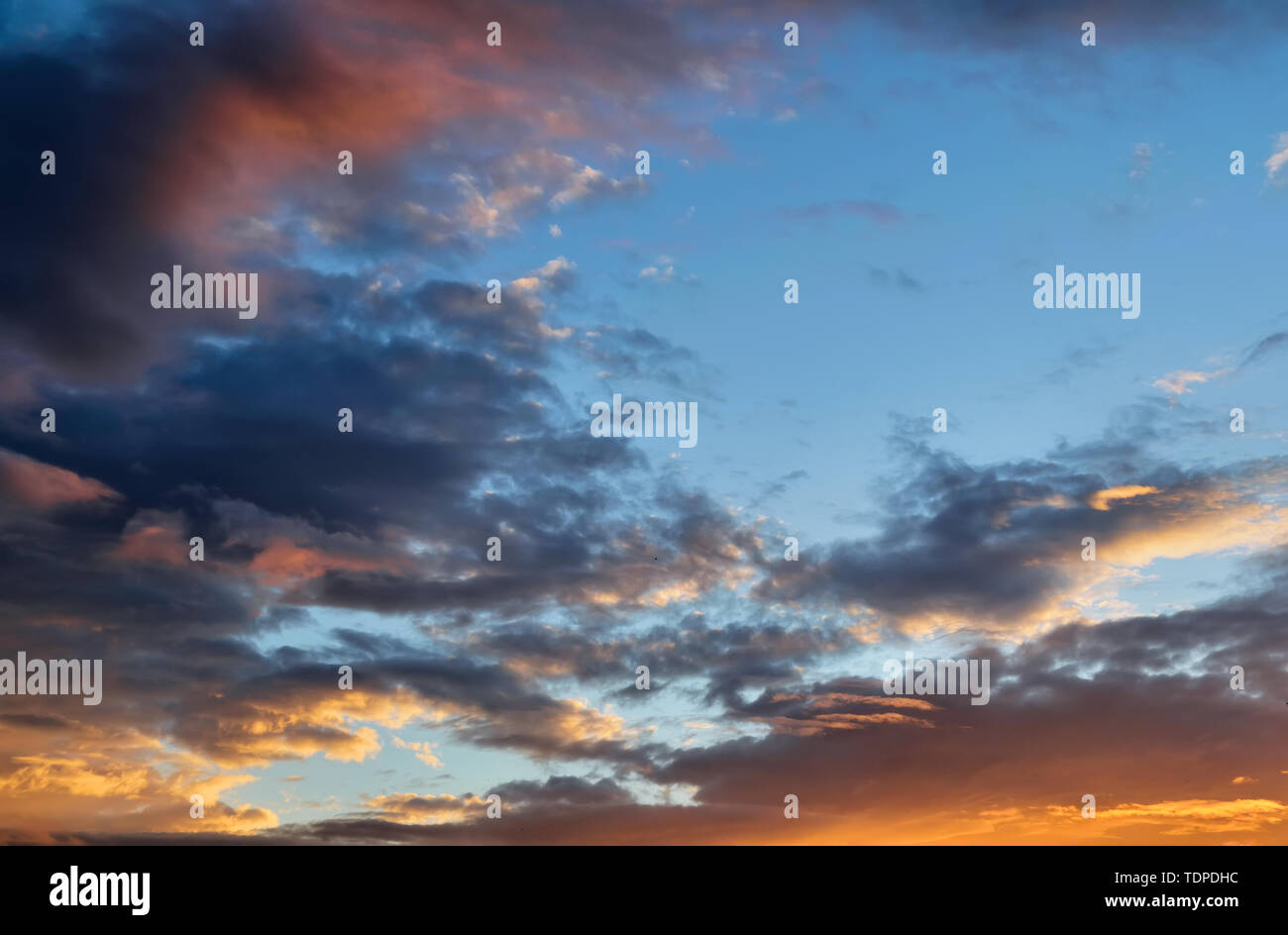 Cumulus sunset clouds with sun setting down. The sky with dark clouds ...