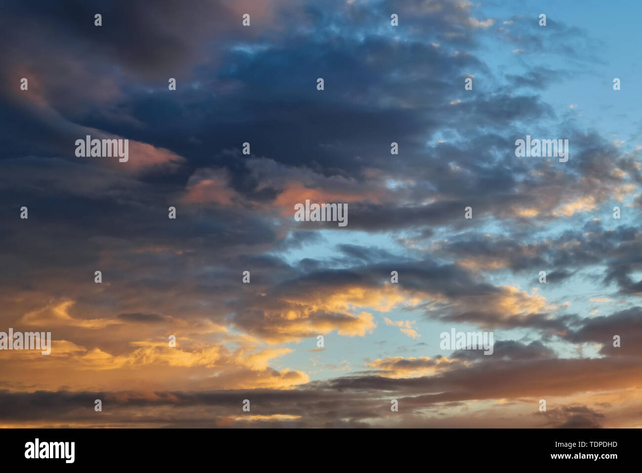Cumulus sunset clouds with sun setting down. The sky with dark clouds ...