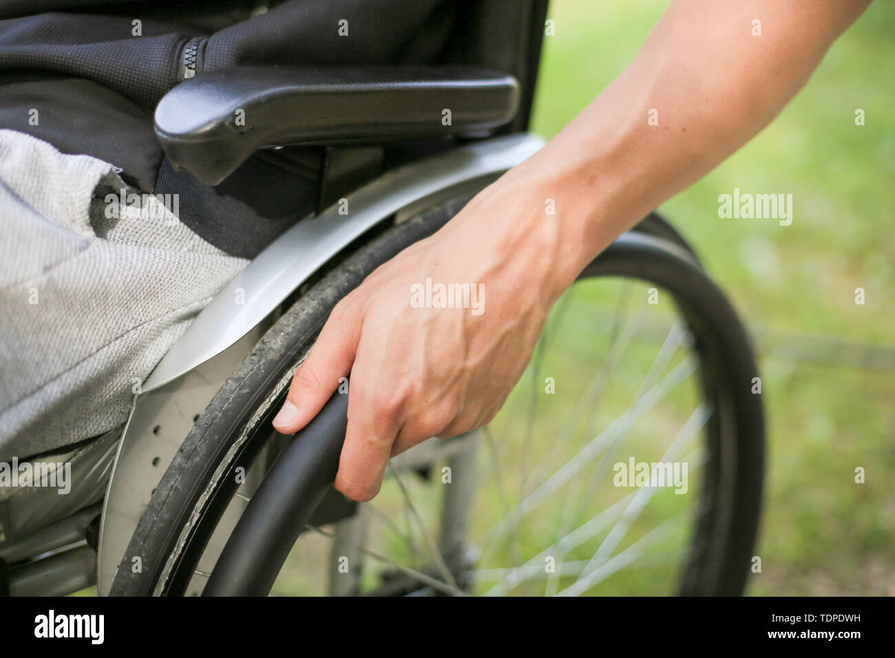 Young disabled or handicapped man sitting on a wheelchair in nature ...