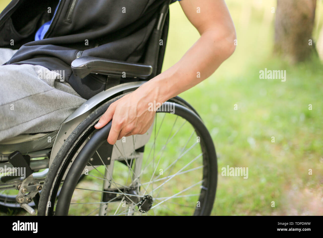 Young disabled or handicapped man sitting on a wheelchair in nature ...
