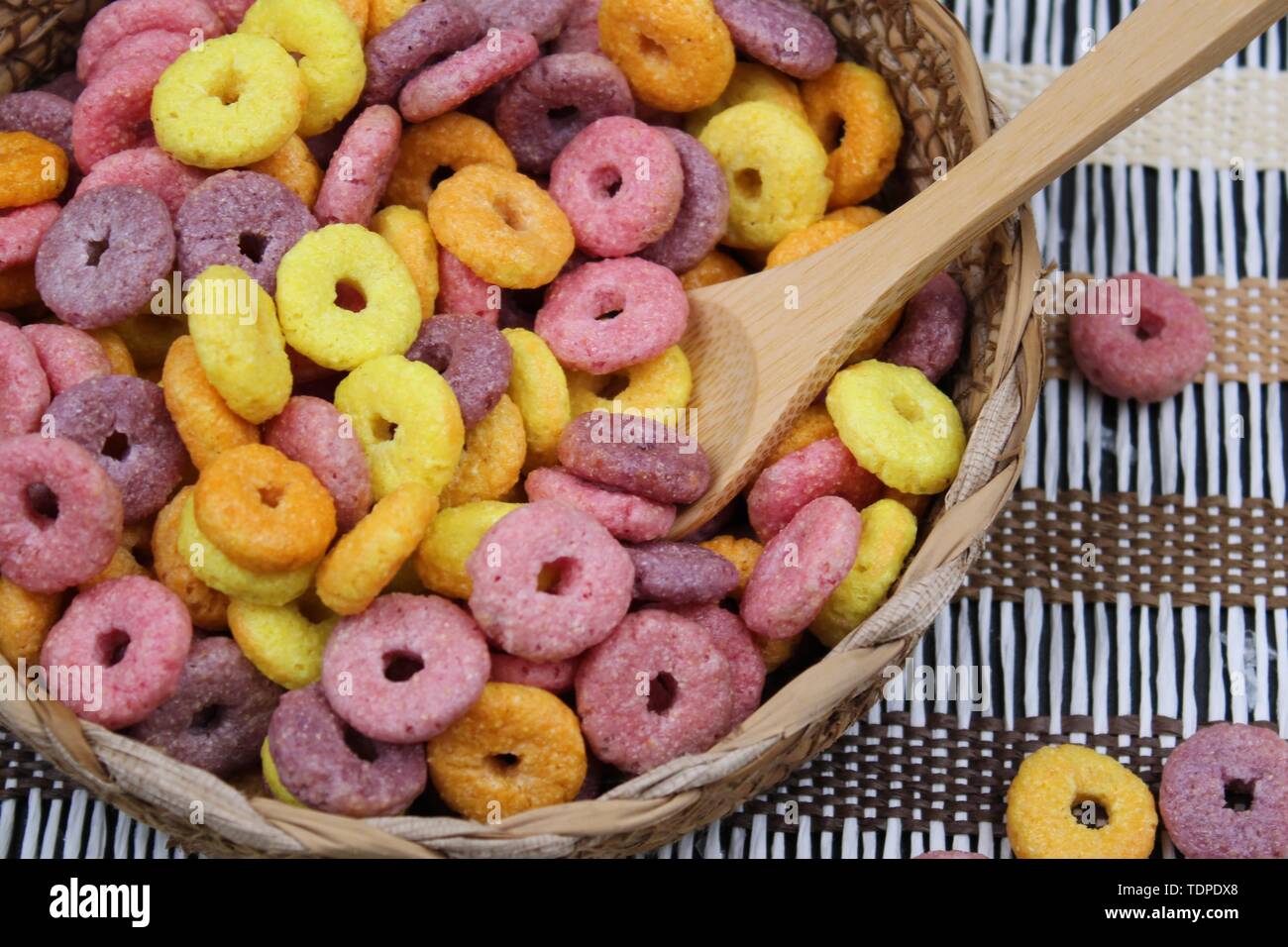 Small wicker bowl with colorful round cereals and wooden spoon Stock ...