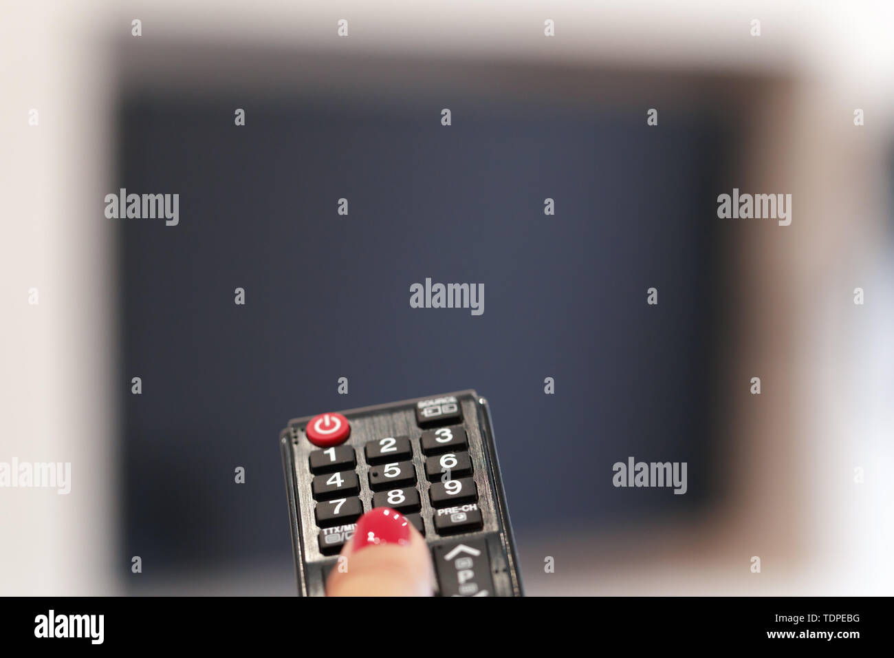 Watching TV and using remote controller Stock Photo - Alamy