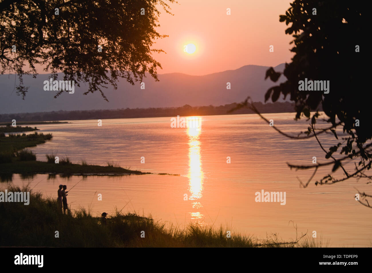 Couple fishing at sunset Stock Photo - Alamy