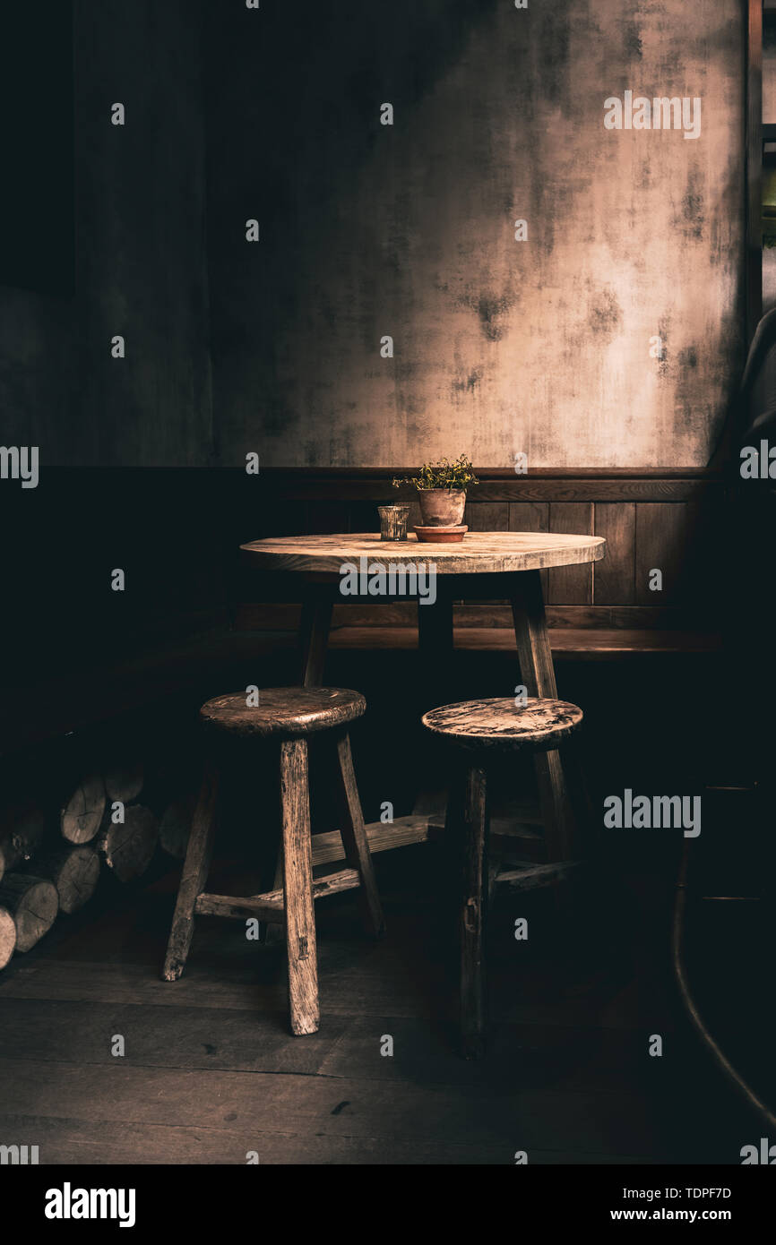 Dramatic photo a woodent table and chairs in a corner of a English Pub ...