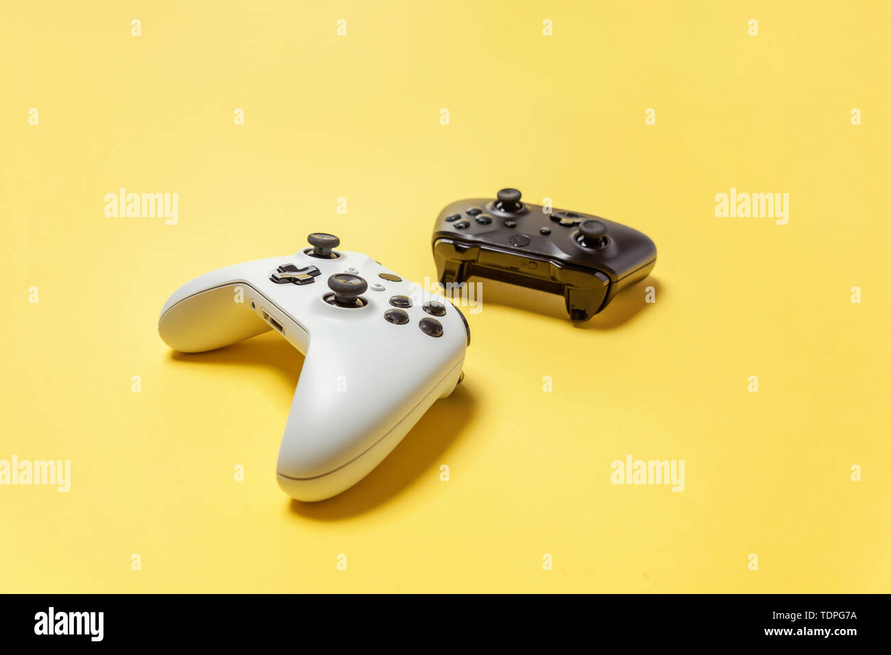 White and black two joystick gamepad, game console on yellow colourful ...