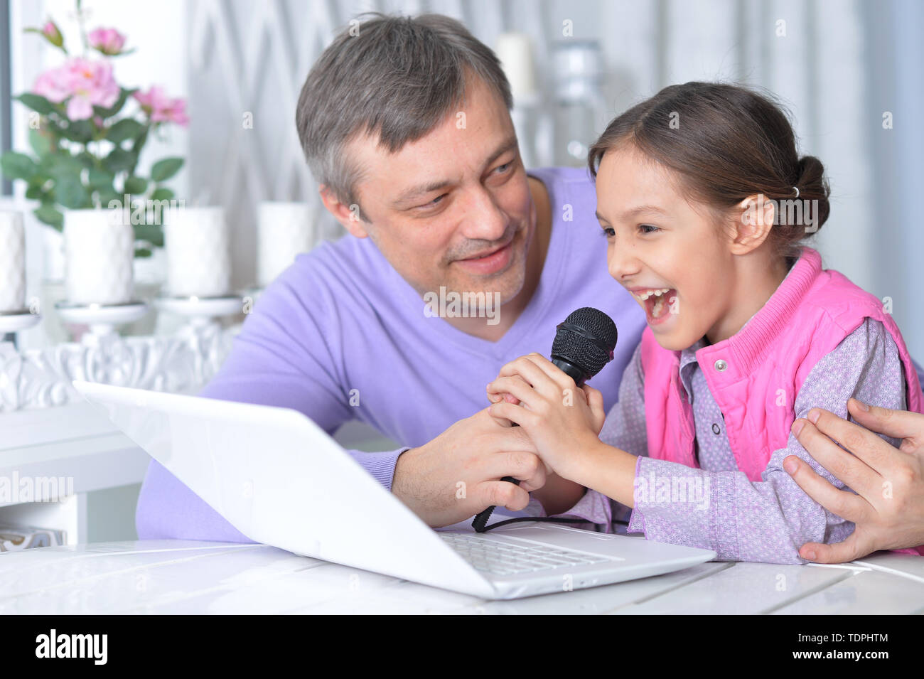 Portrait of father with little daughter singing karaoke Stock Photo - Alamy
