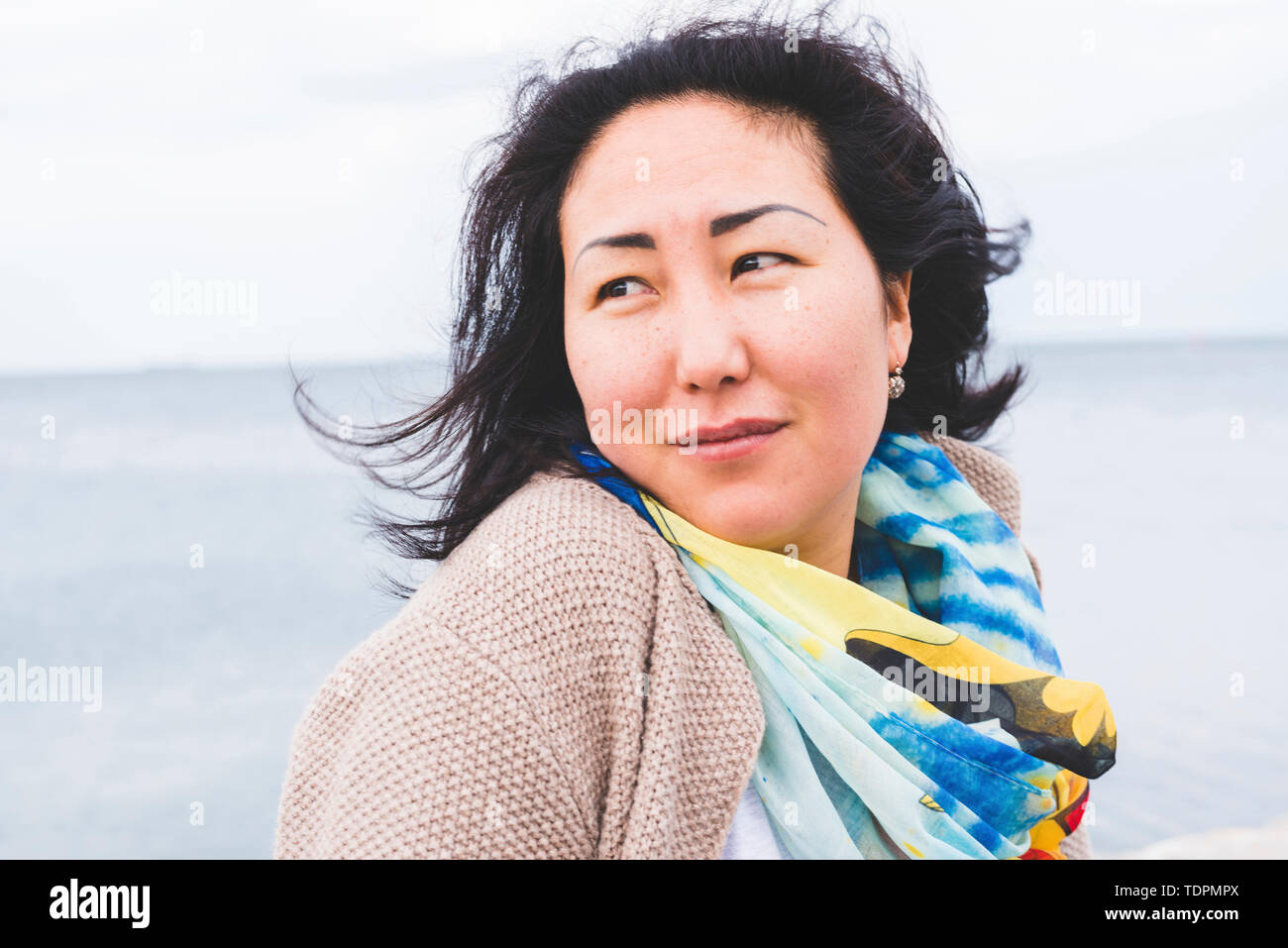 Portrait of the side view of a woman with the ocean in the background ...