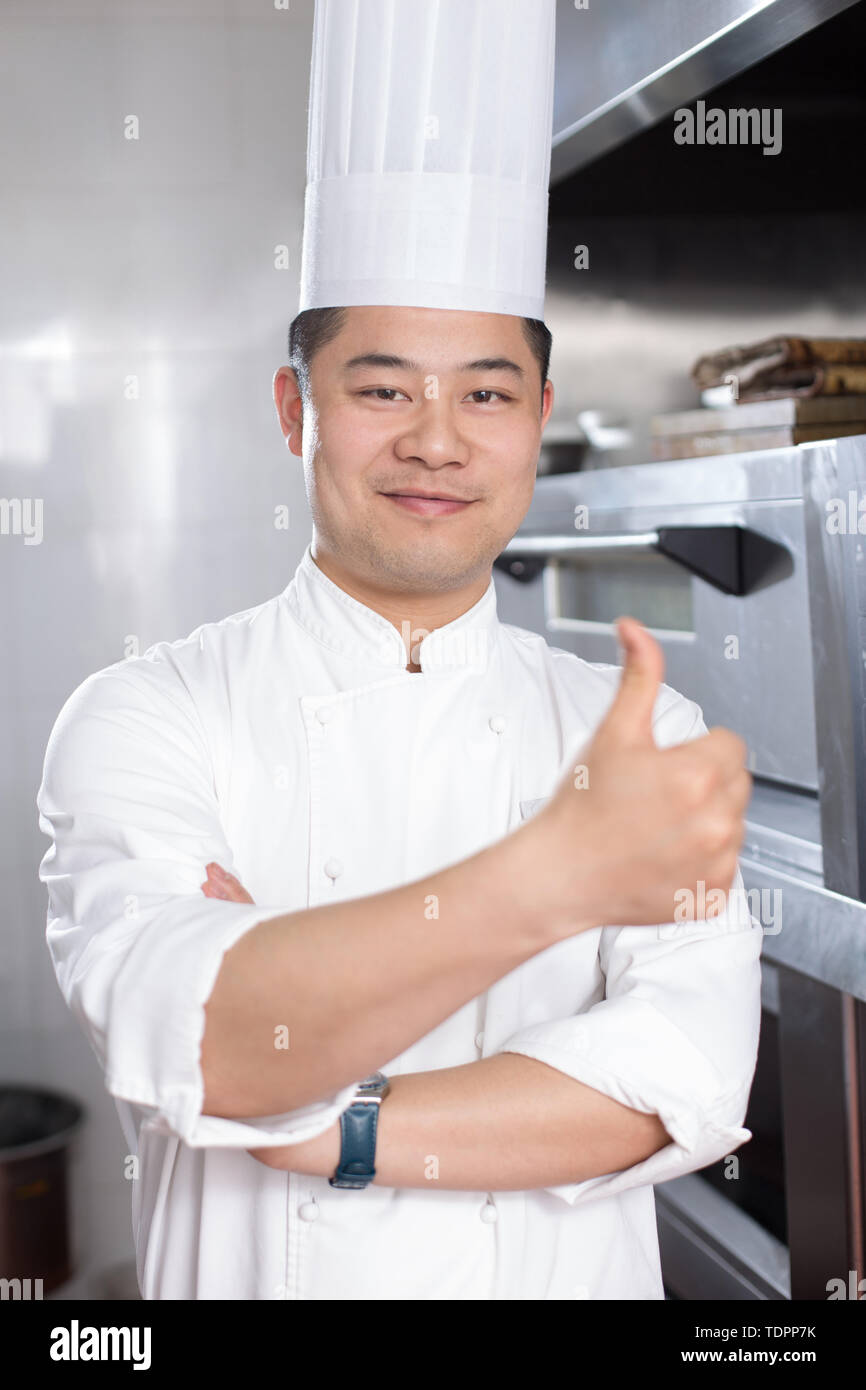 young chinese man chelf in modern kitchen Stock Photo - Alamy