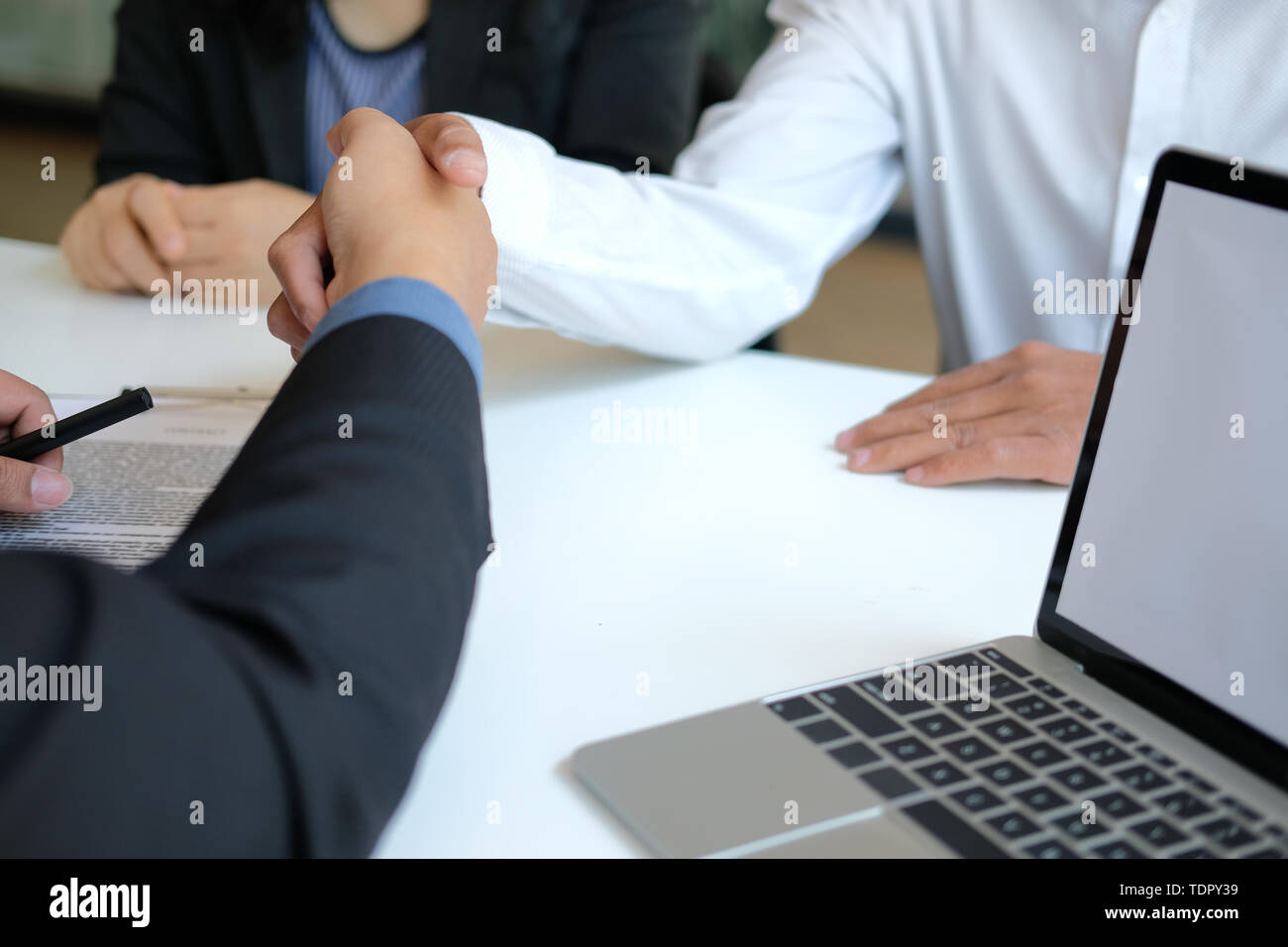 couple shaking hands to realtor mortgage insurance broker lawyer. customer handshaking with ...