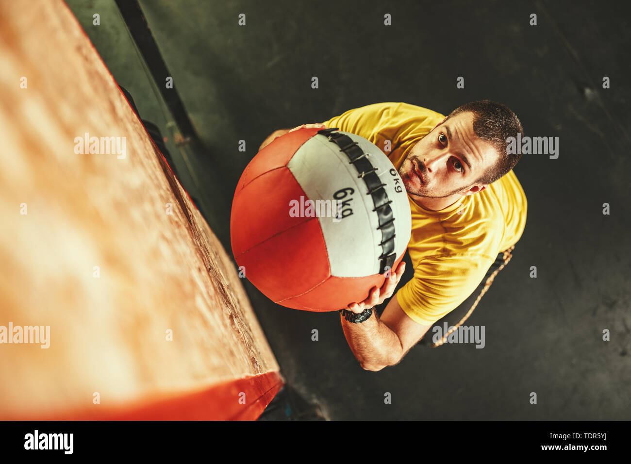 Handsome young muscular man is doing exercise with wall ball at the gym ...
