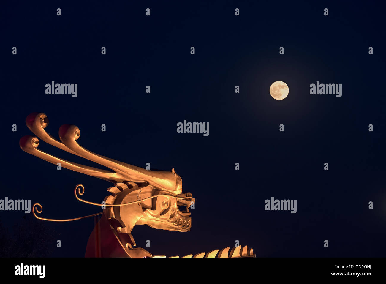 Dragon looks back at the moon Stock Photo - Alamy