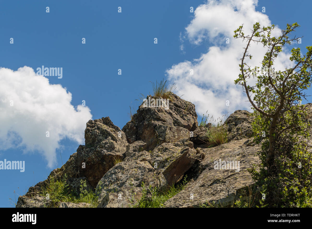 stone hill against a blue sky and clouds view from the bottom up Stock ...