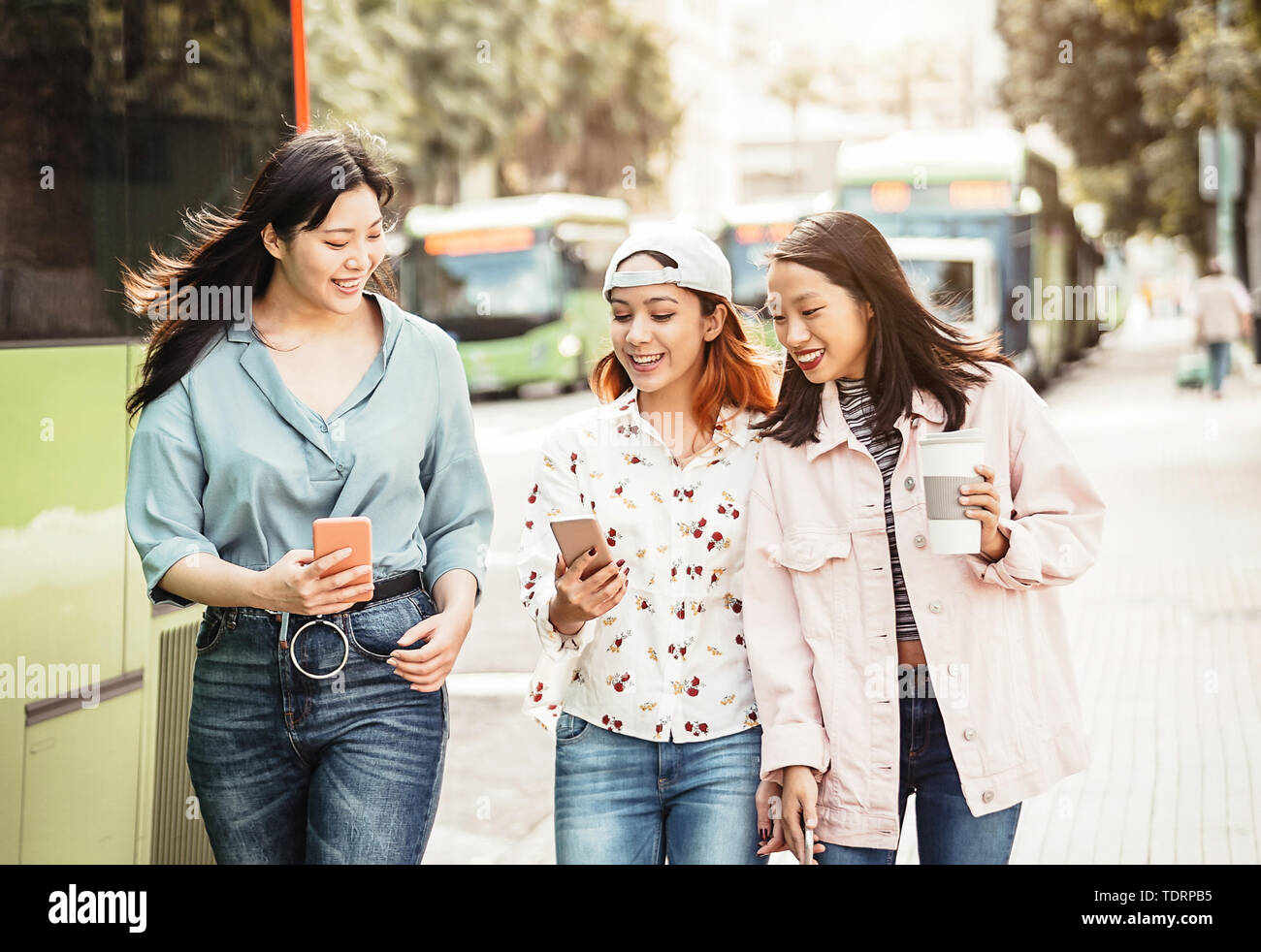 Happy Asian girls using mobile phone outdoor - Young millennial people ...