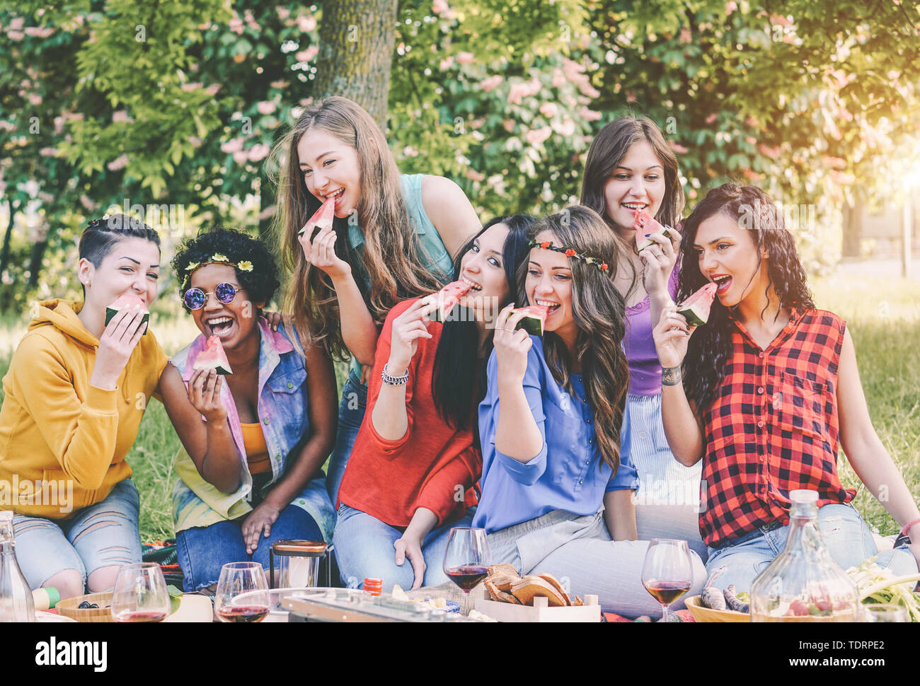 Happy girls eating watermelon at picnic dinner in the garden - Young ...