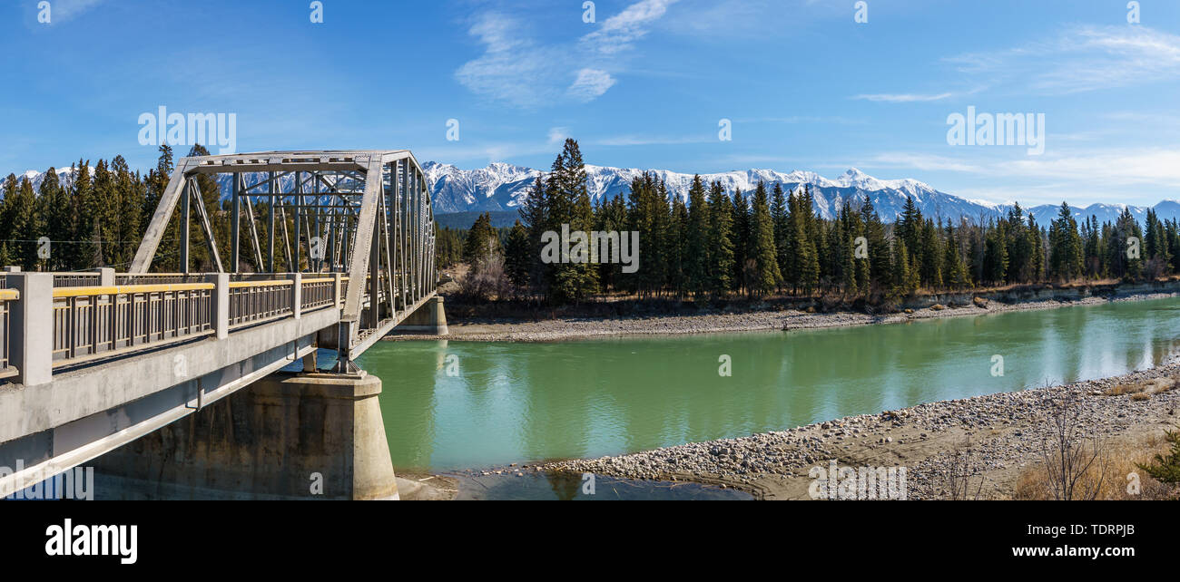 metal bridge over the river with green water in spring with mountains ...