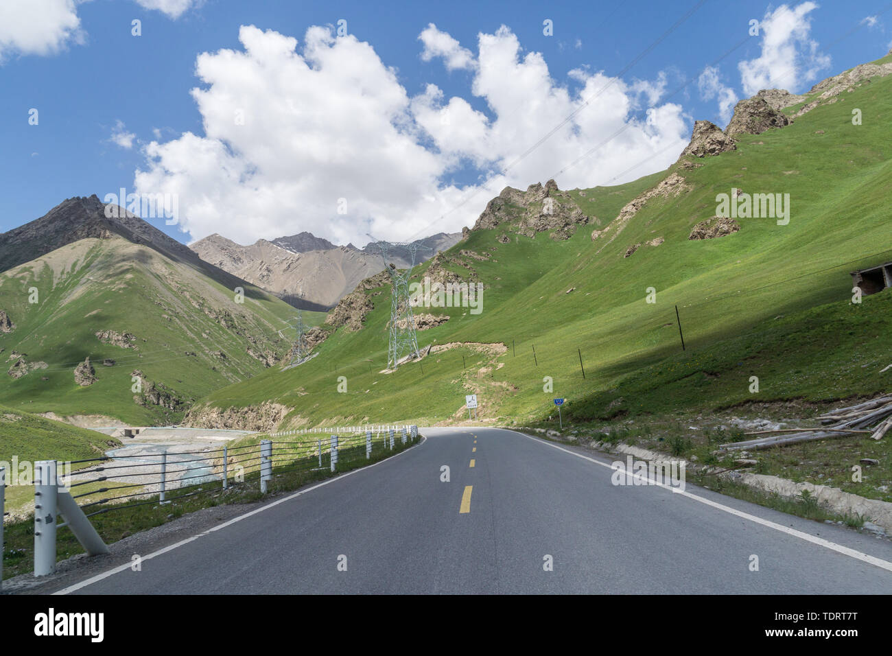 Summer Xinjiang alpine grassland road car background Stock Photo - Alamy