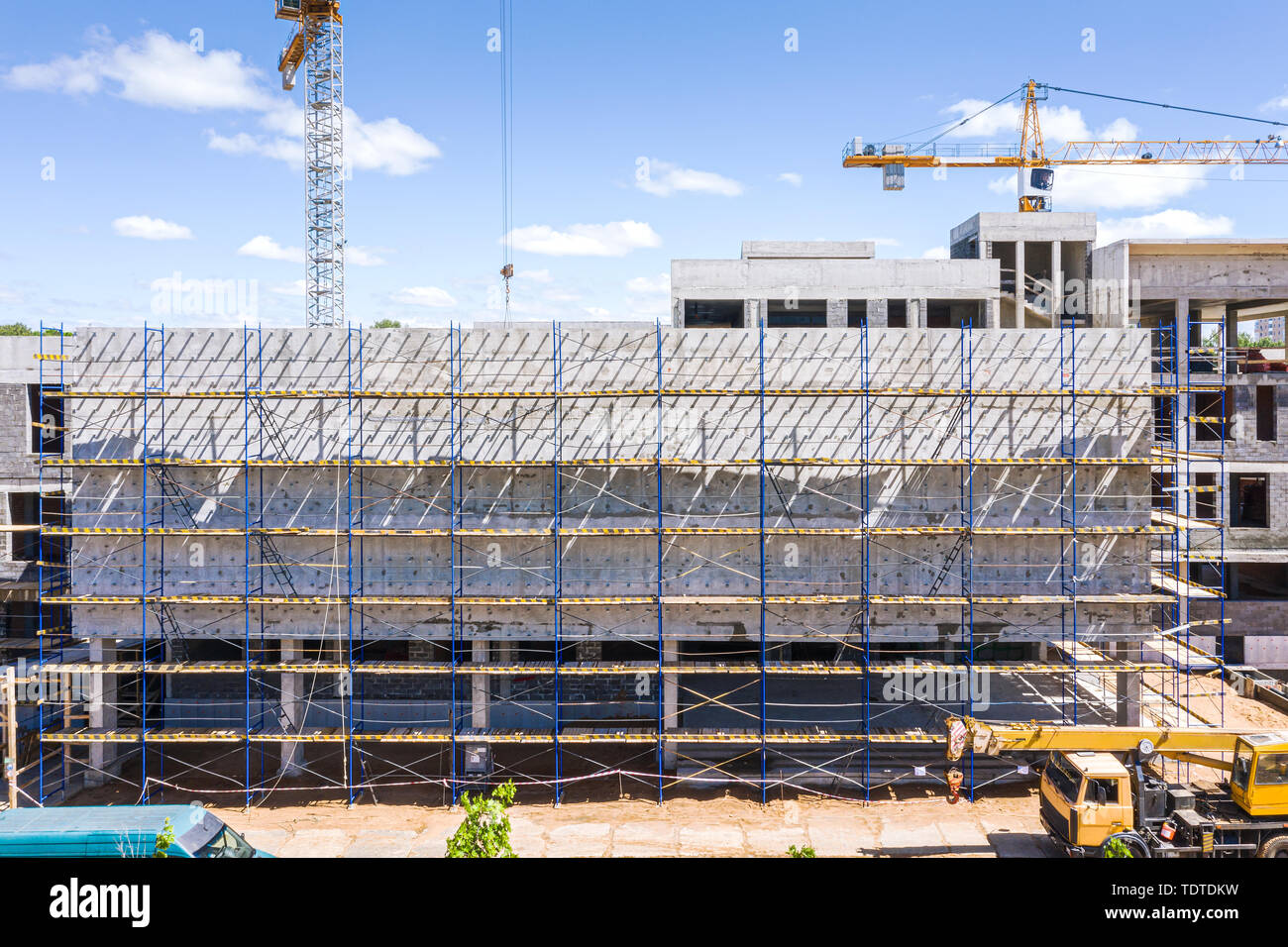 construction site with unfinished building covered in scaffolding ...