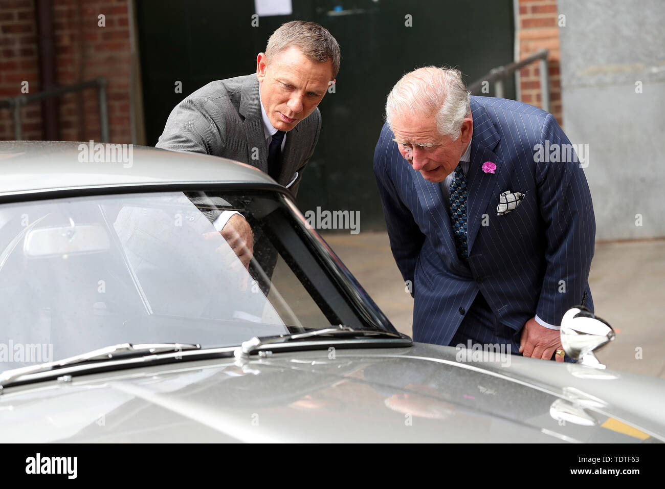 The Prince of Wales looks at an Aston Martin DB5 with actor Daniel ...