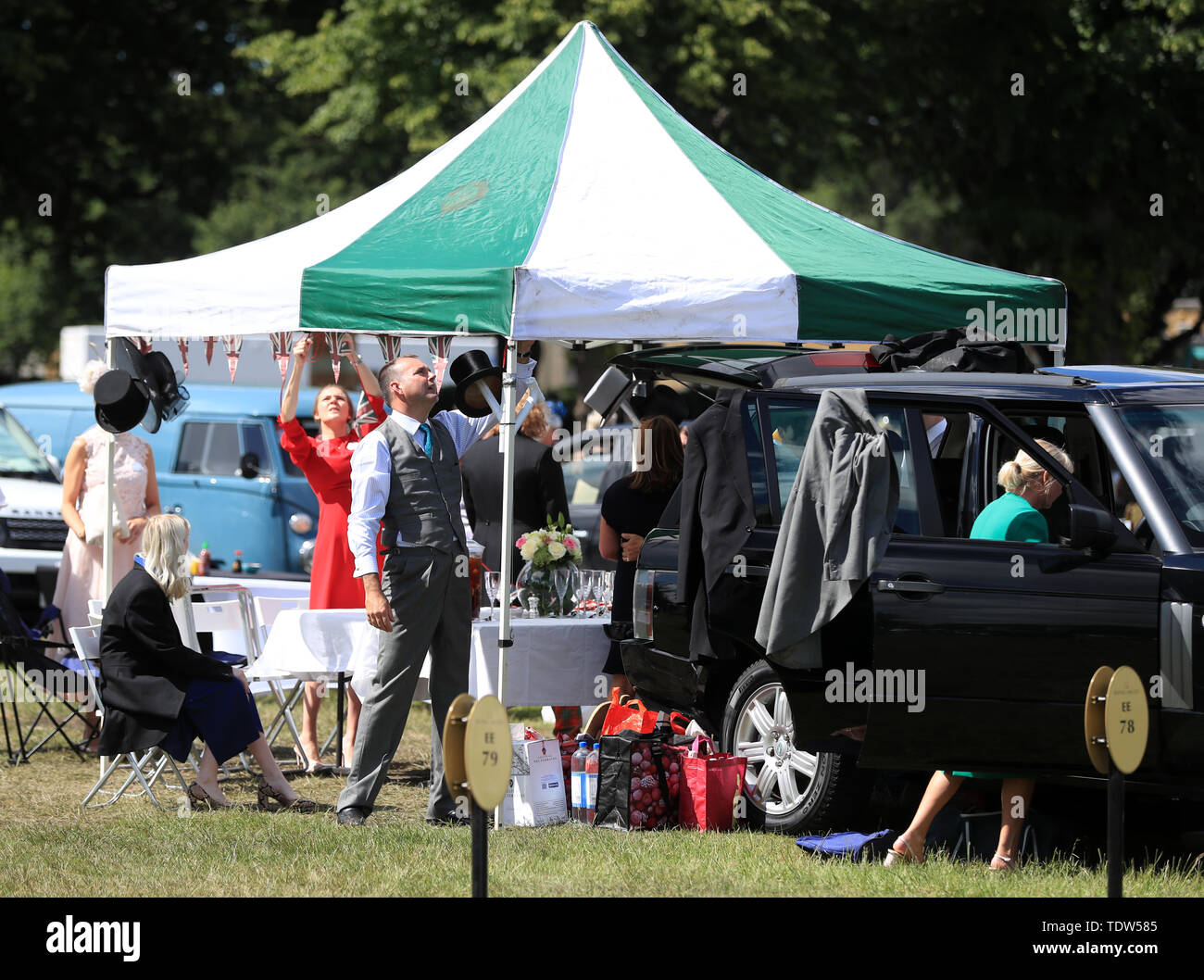 Racegoers put up a Marquee in the car park as they arrive for day four ...
