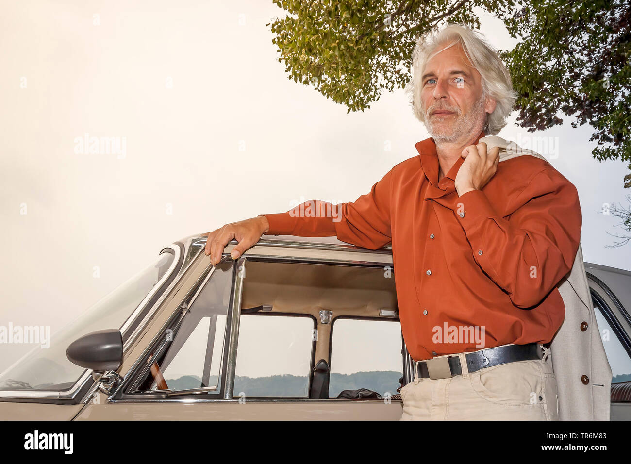 senior standing at his oldtimer Stock Photo - Alamy