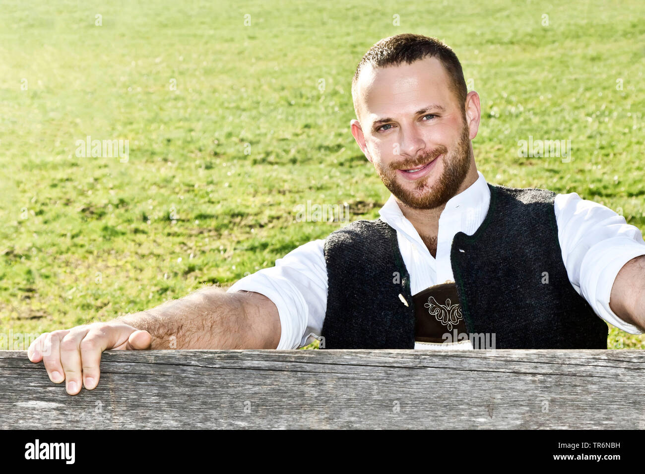 man in Bavarian traditional clothing at a pasture fence, Germany ...