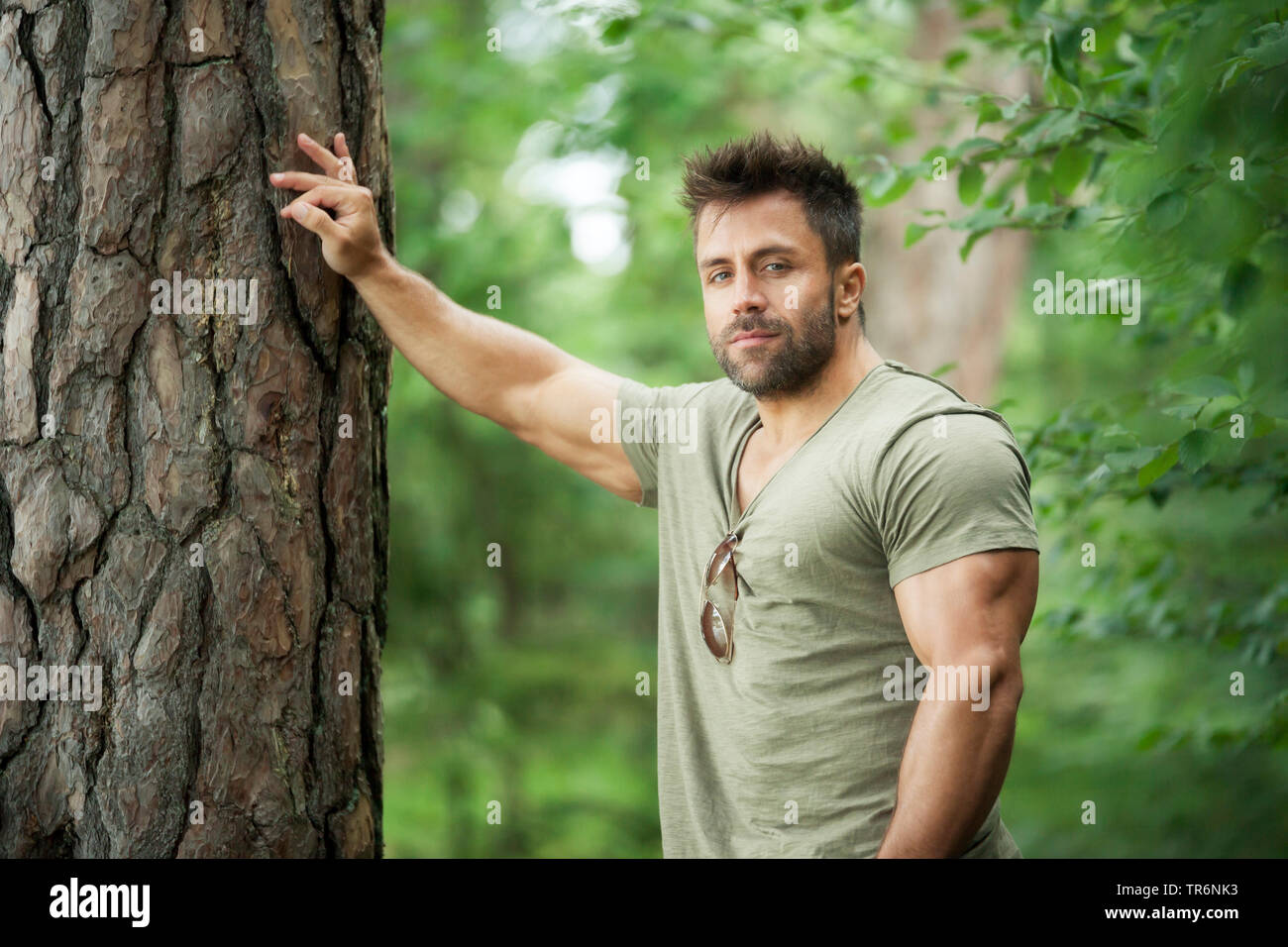 muscular man in nature, standing at a tree, Germany Stock Photo - Alamy